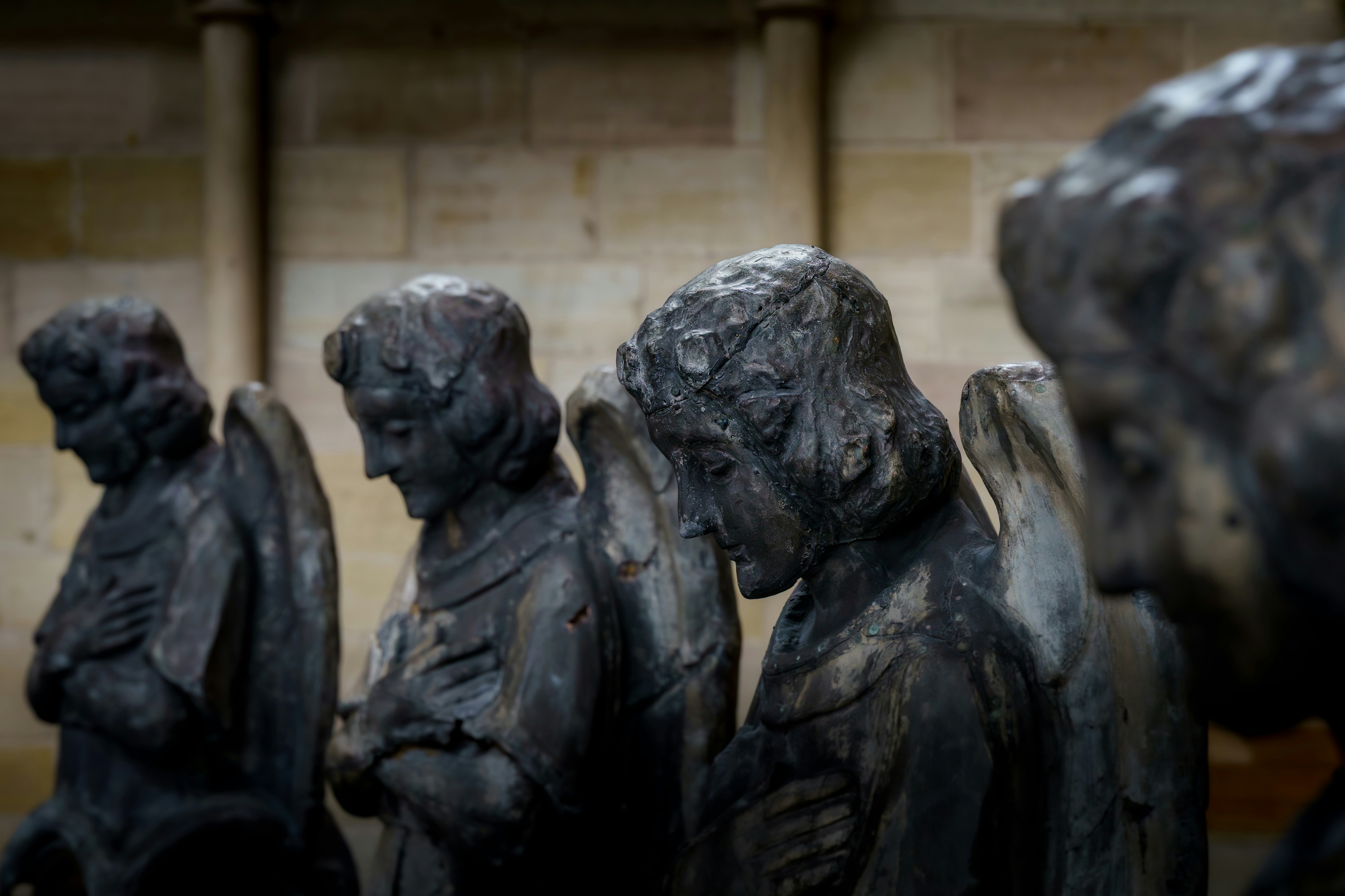 Somber Choir: A Row of Weathered Statues Bending Toward Silence