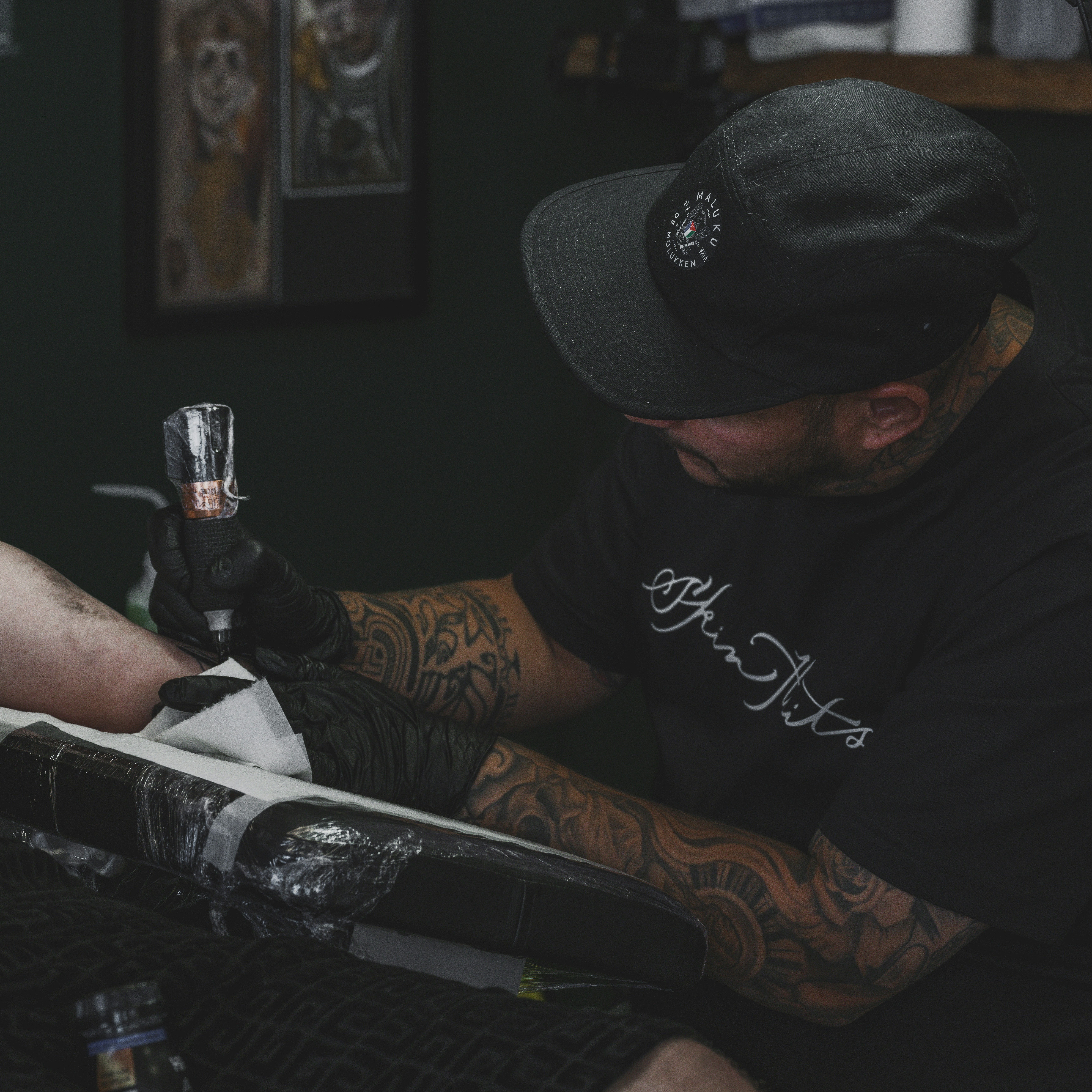 Inked Handcraft: Tattoo Artist Focused on a Tattoo Session
