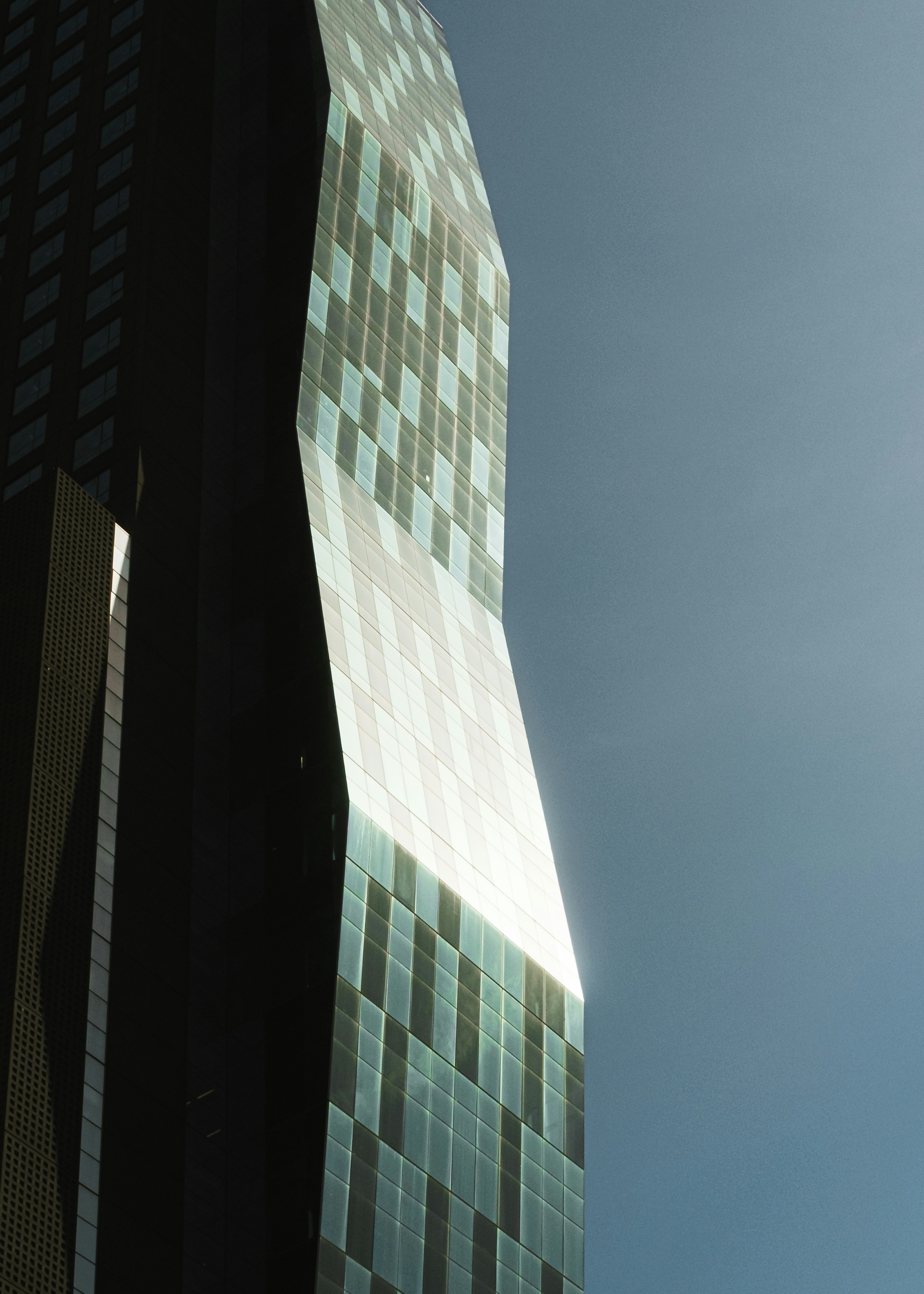 Glinting Facade: A Leaning Tower of Glass Reaching for Sky