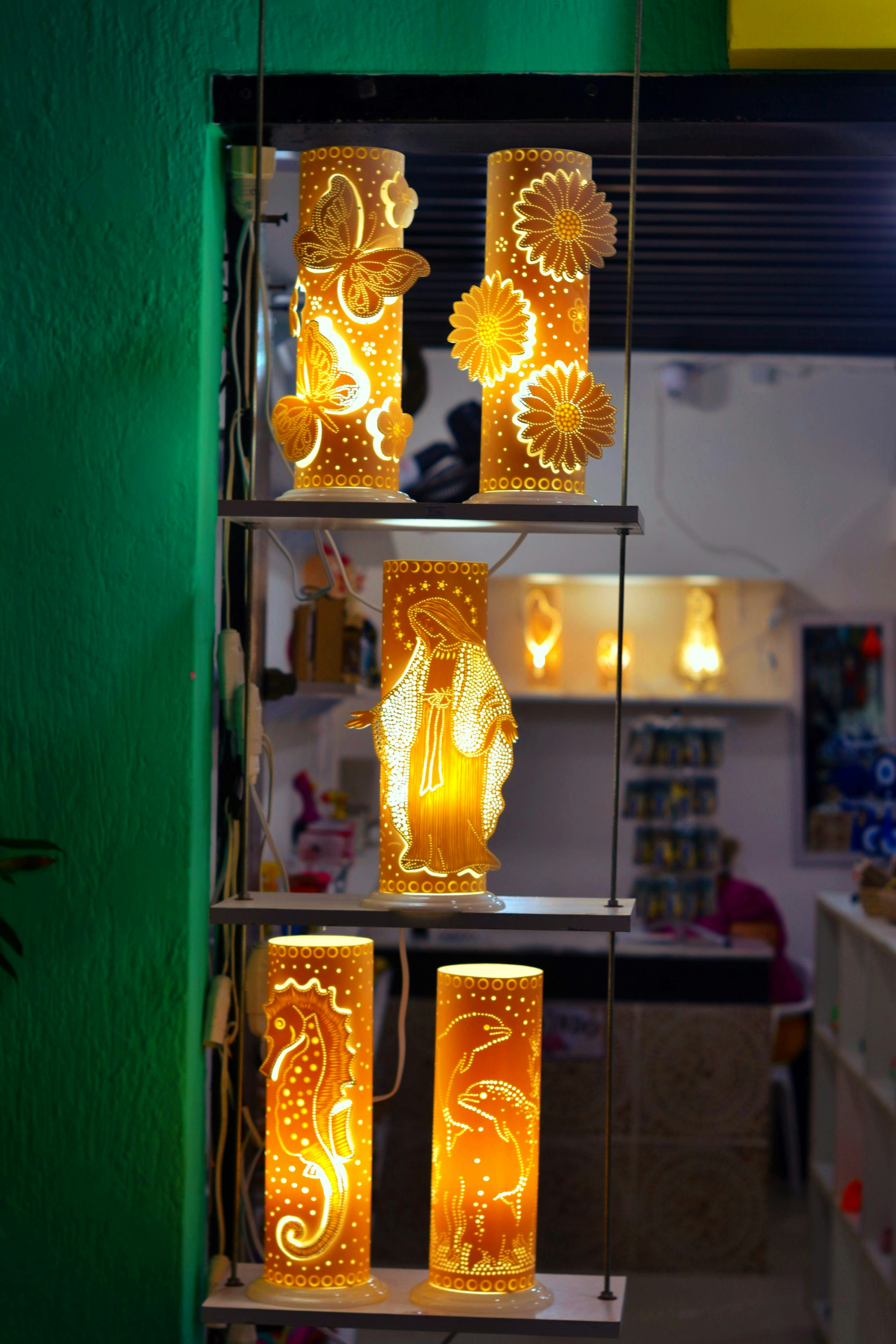 Lanterns of Light: Glowing Sculpted Cylinders in a Greenscape Shopfront