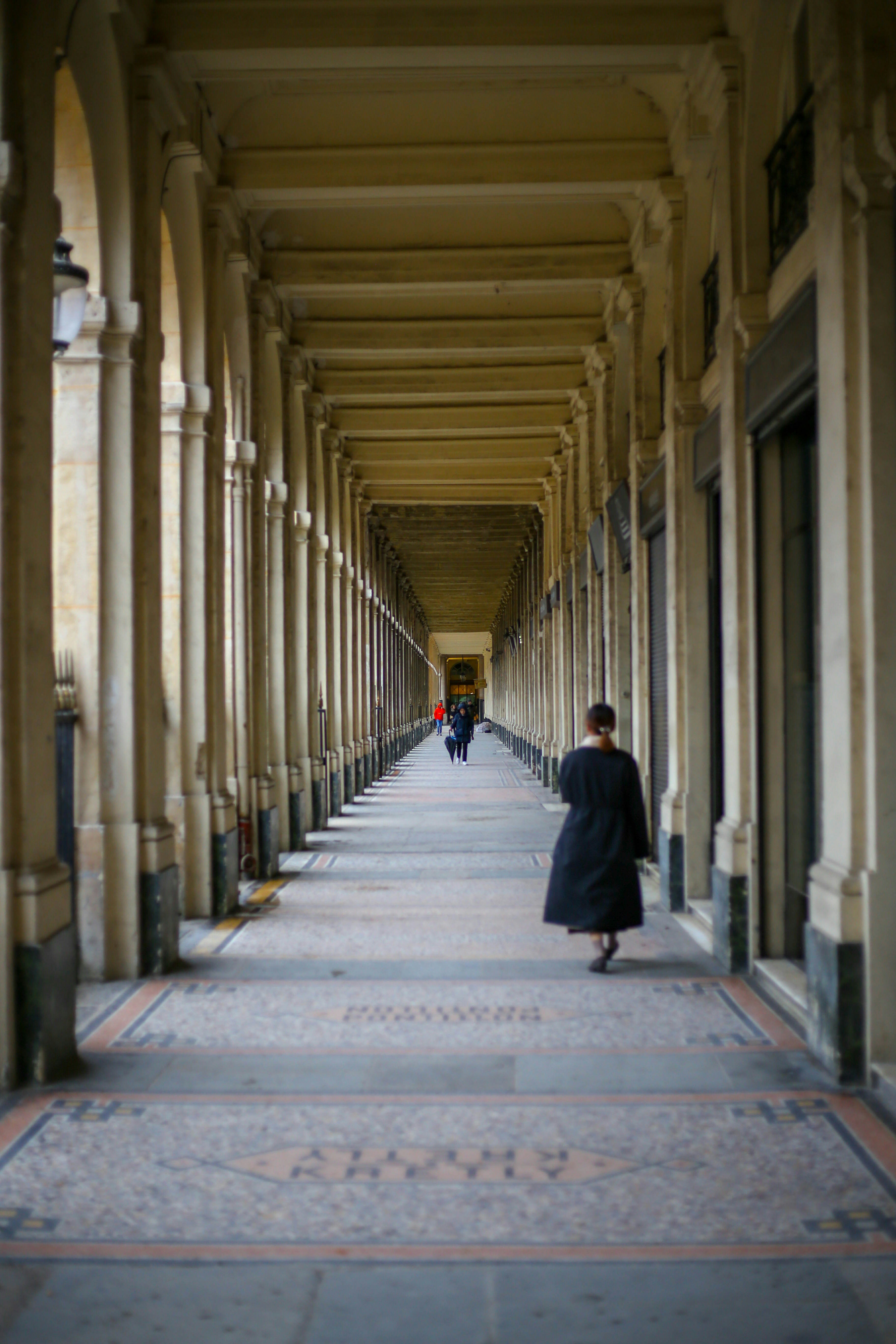 Silhouetted Stroll Under Carved Arches