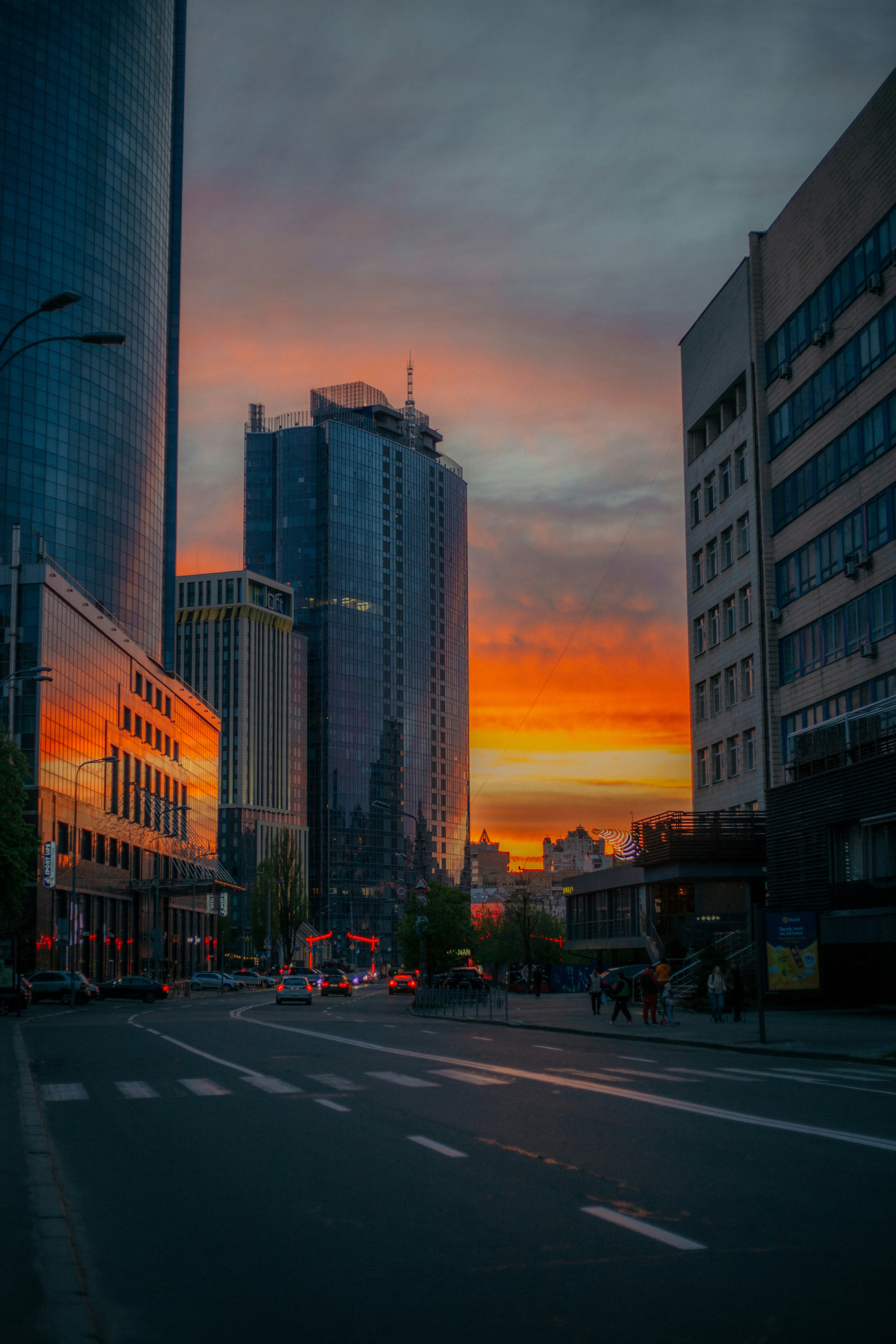Sunset Over the Glass Canopy: City Street at Dusk