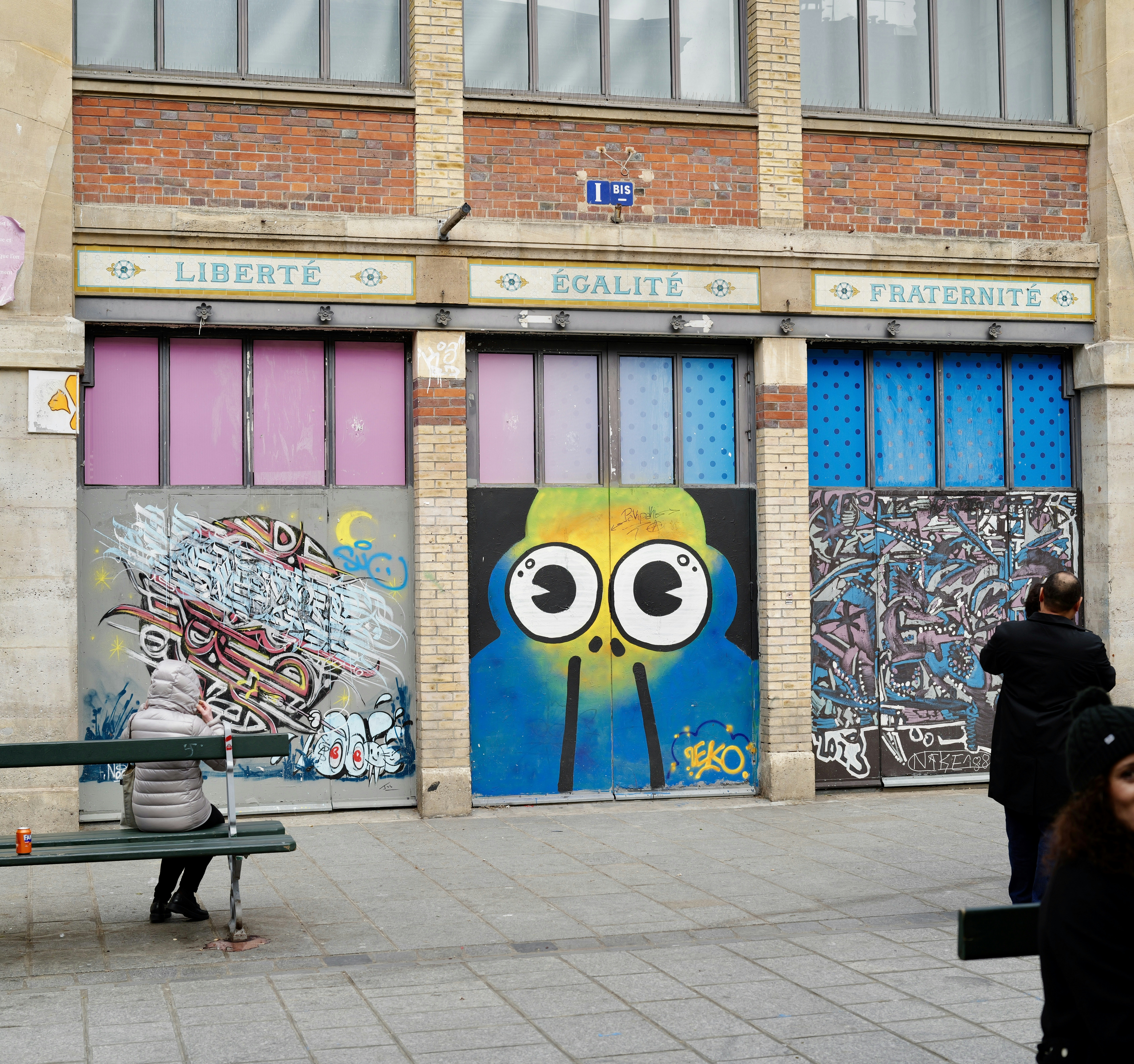 Vibrant Street Graffiti Center: Bold Eyes in the Blue Wall