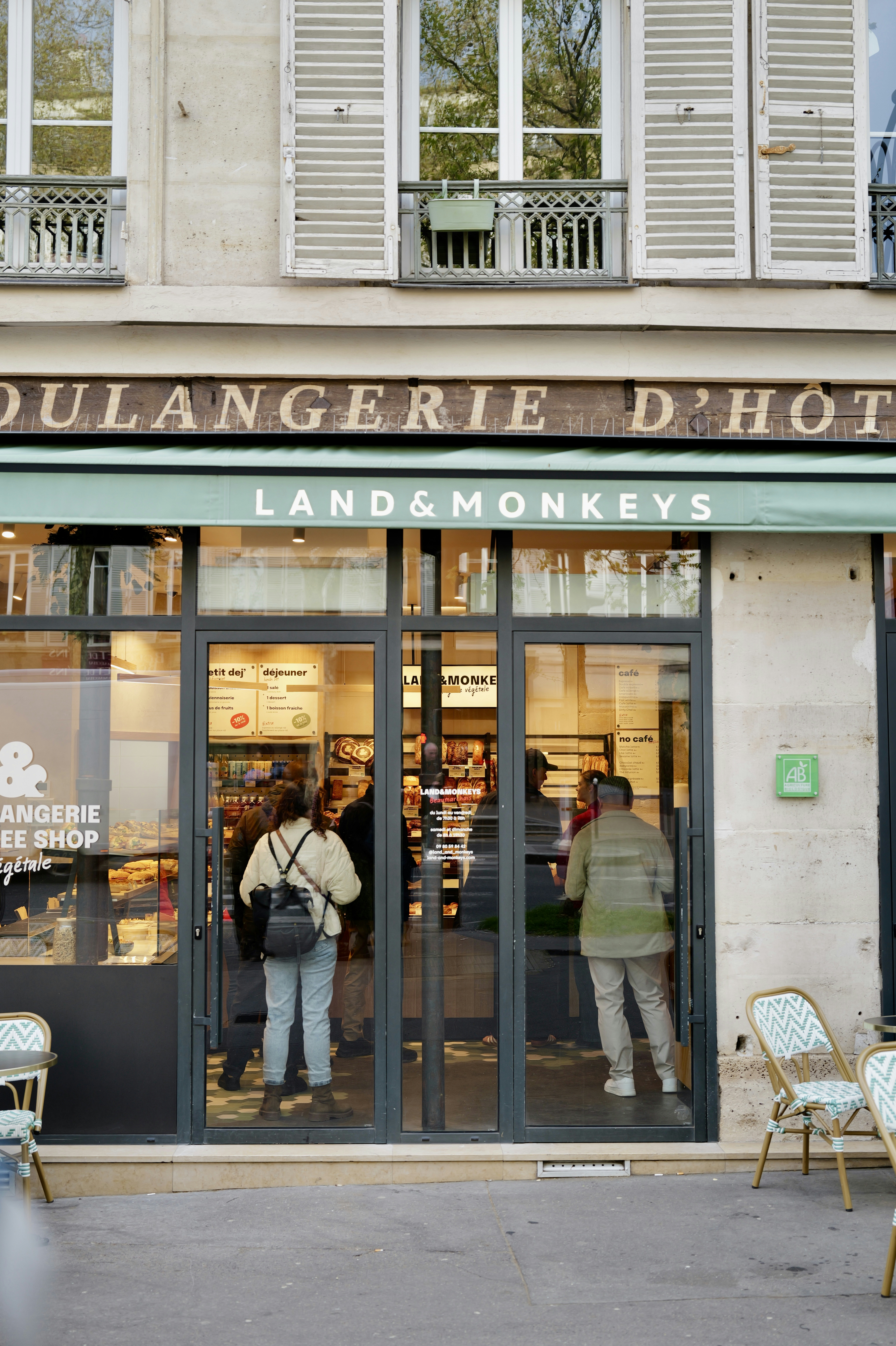 Land & Monkeys Café: People Inside a Busy Paris Bakery Front