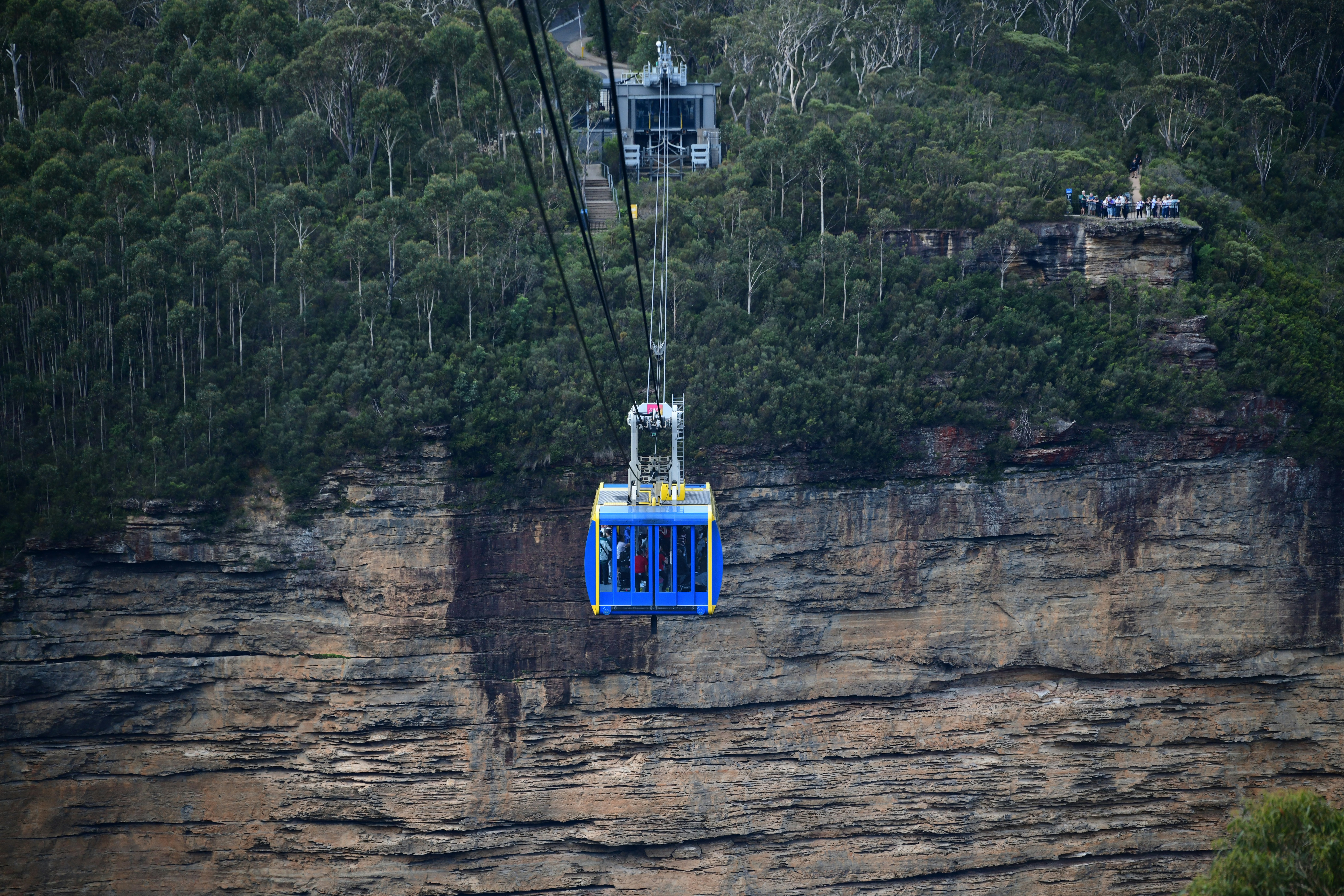 Blue Gondola Crossing the Cliff Face