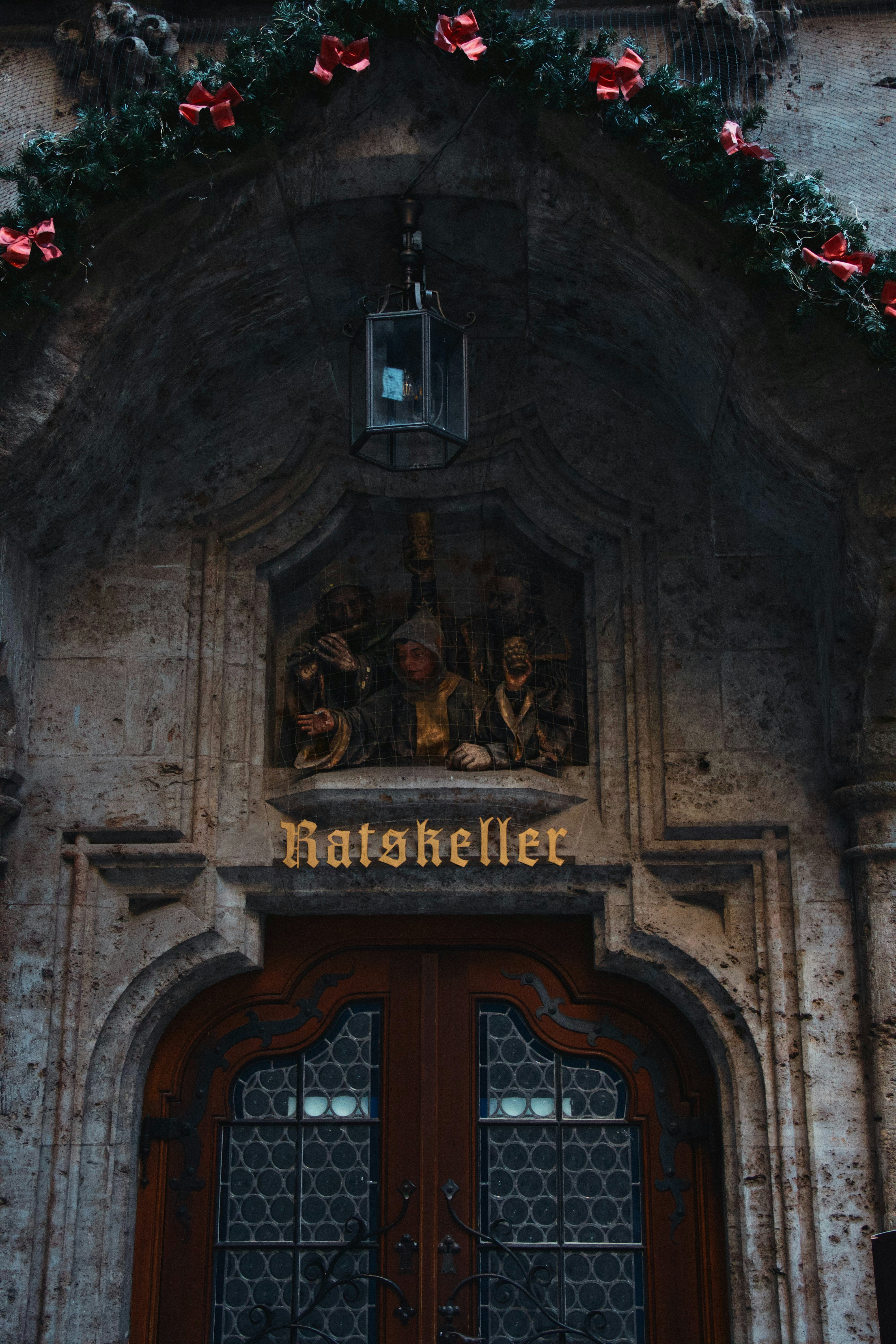 Carved relic over the doorway: a weathered façade crowned with garlands