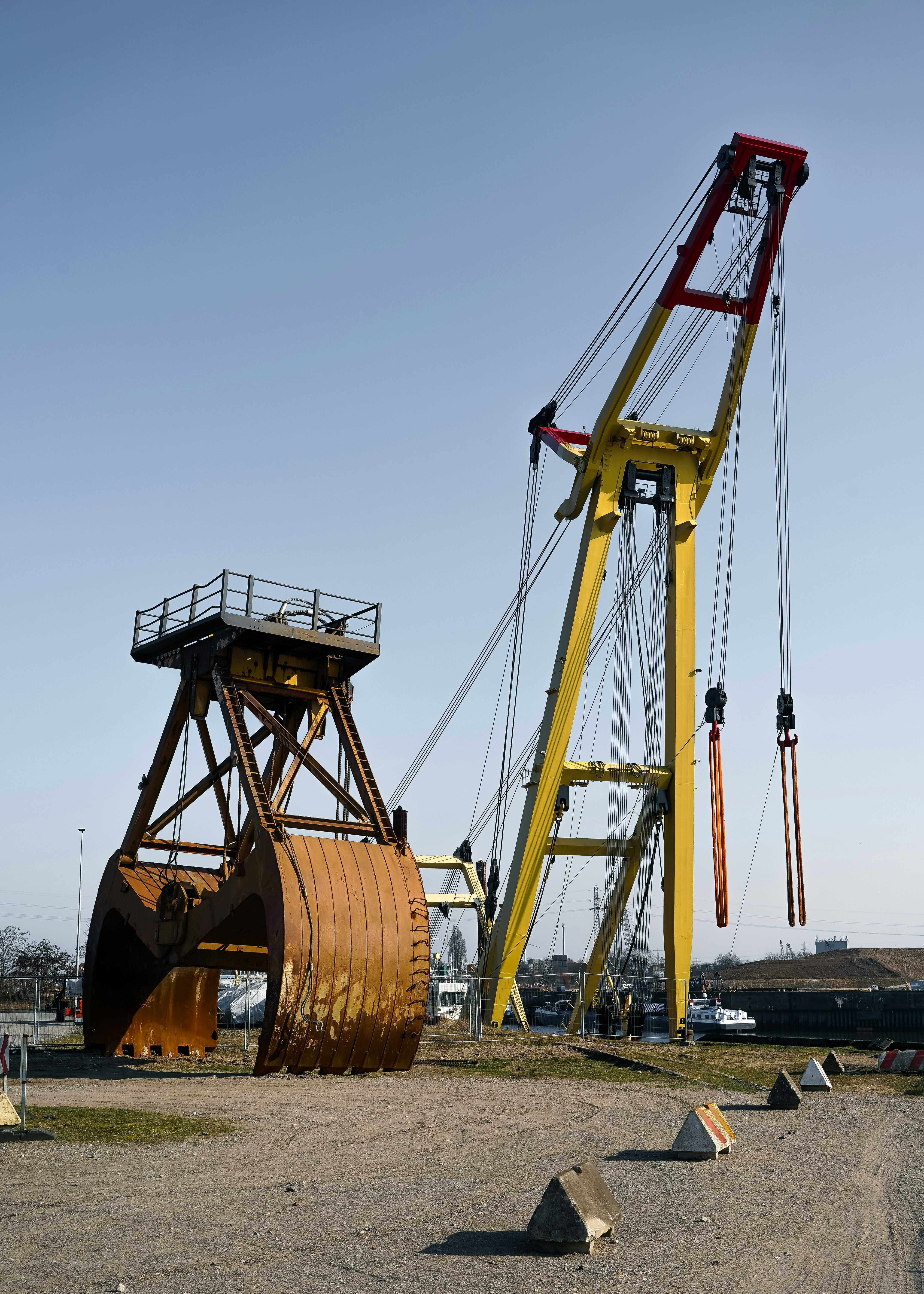 Industrial Giant: The Yellow Crane Reaches Over a Rusted Dredger