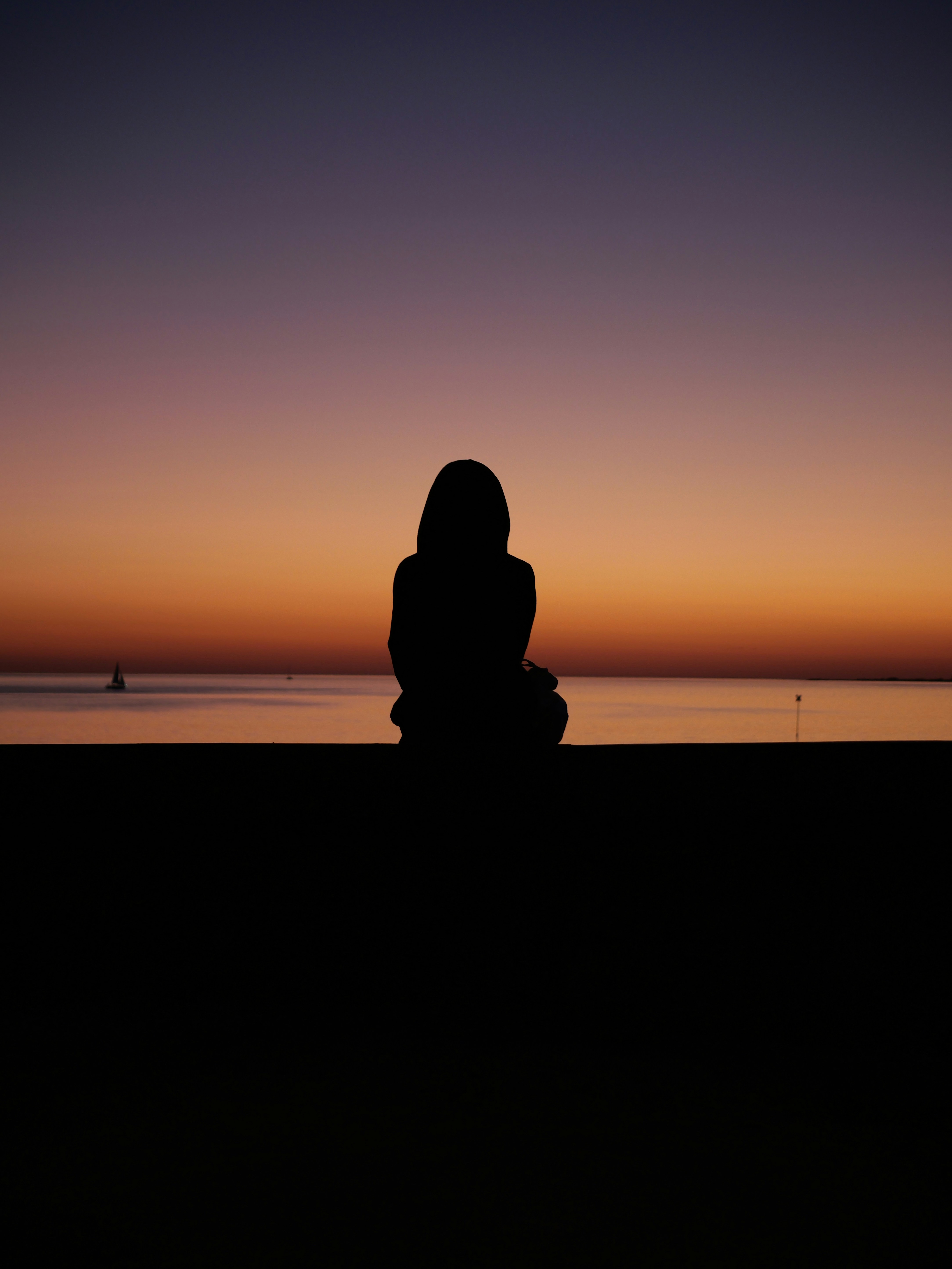 Silhouette at Dusk: A Quiet Figure by the Sea