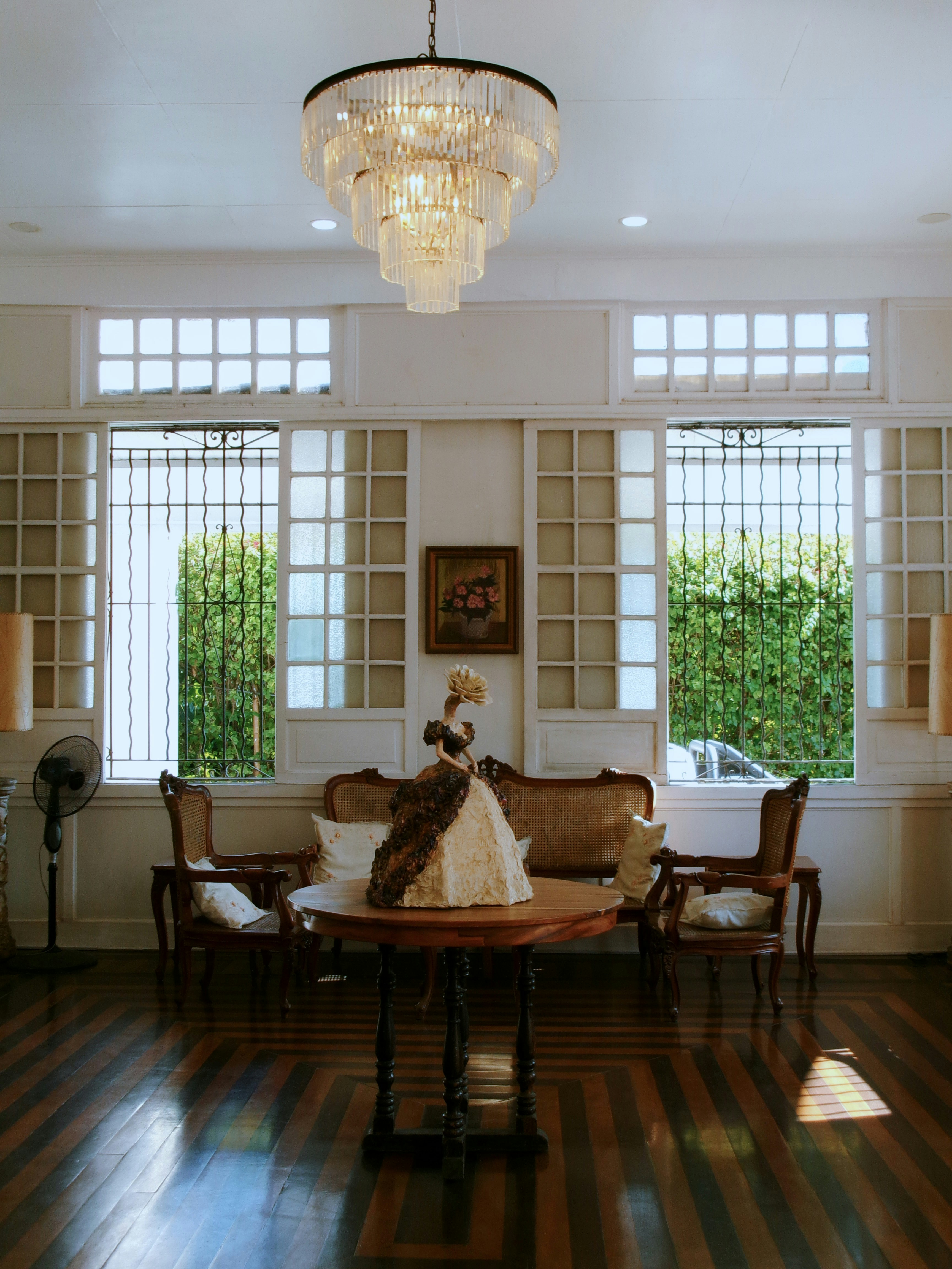 Centerpiece in a Sunlit Salon: A Vintage Table with Feathered Dress statuette