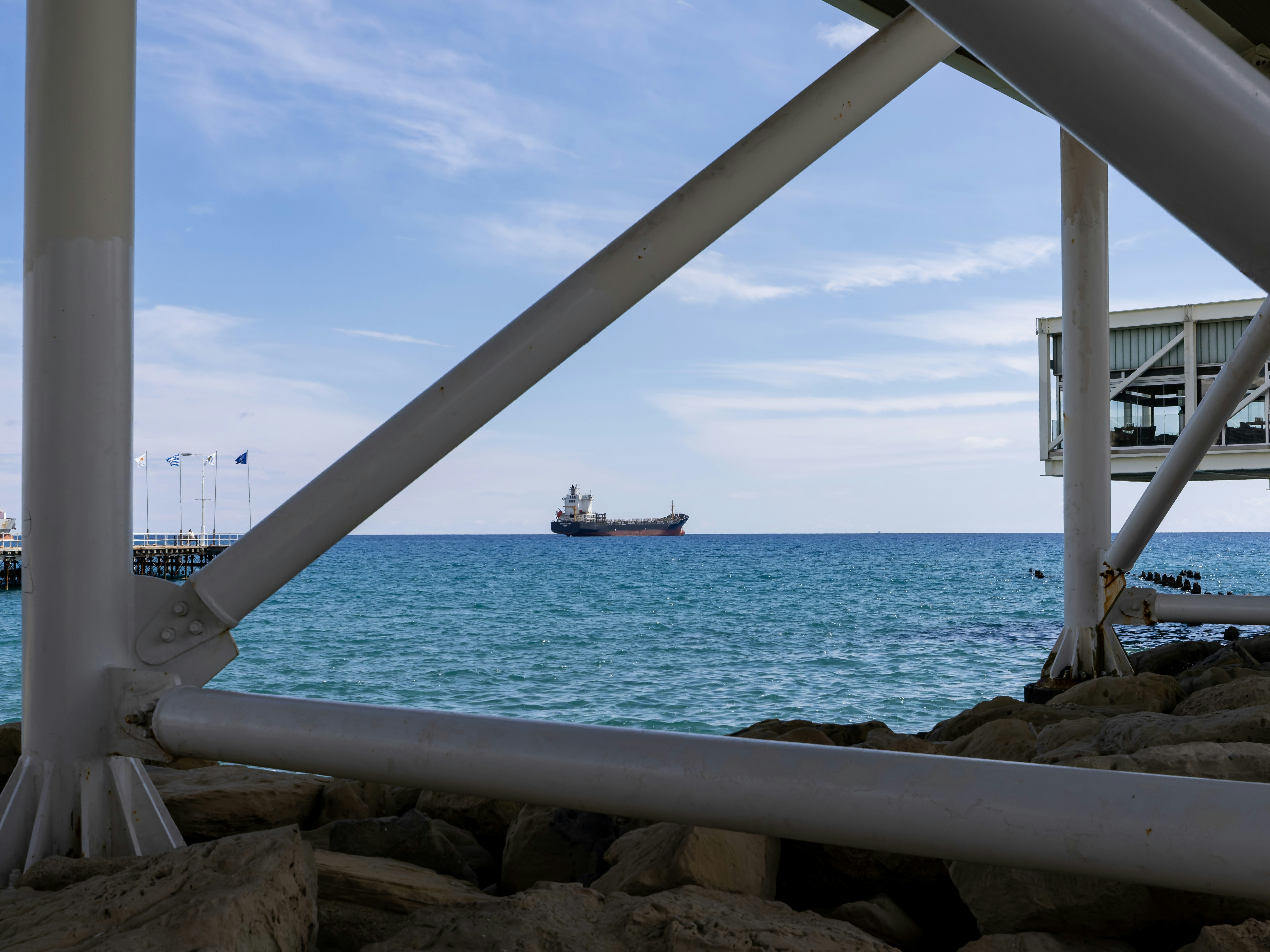Harbor at Anchor: A Ship Between Structural Beams