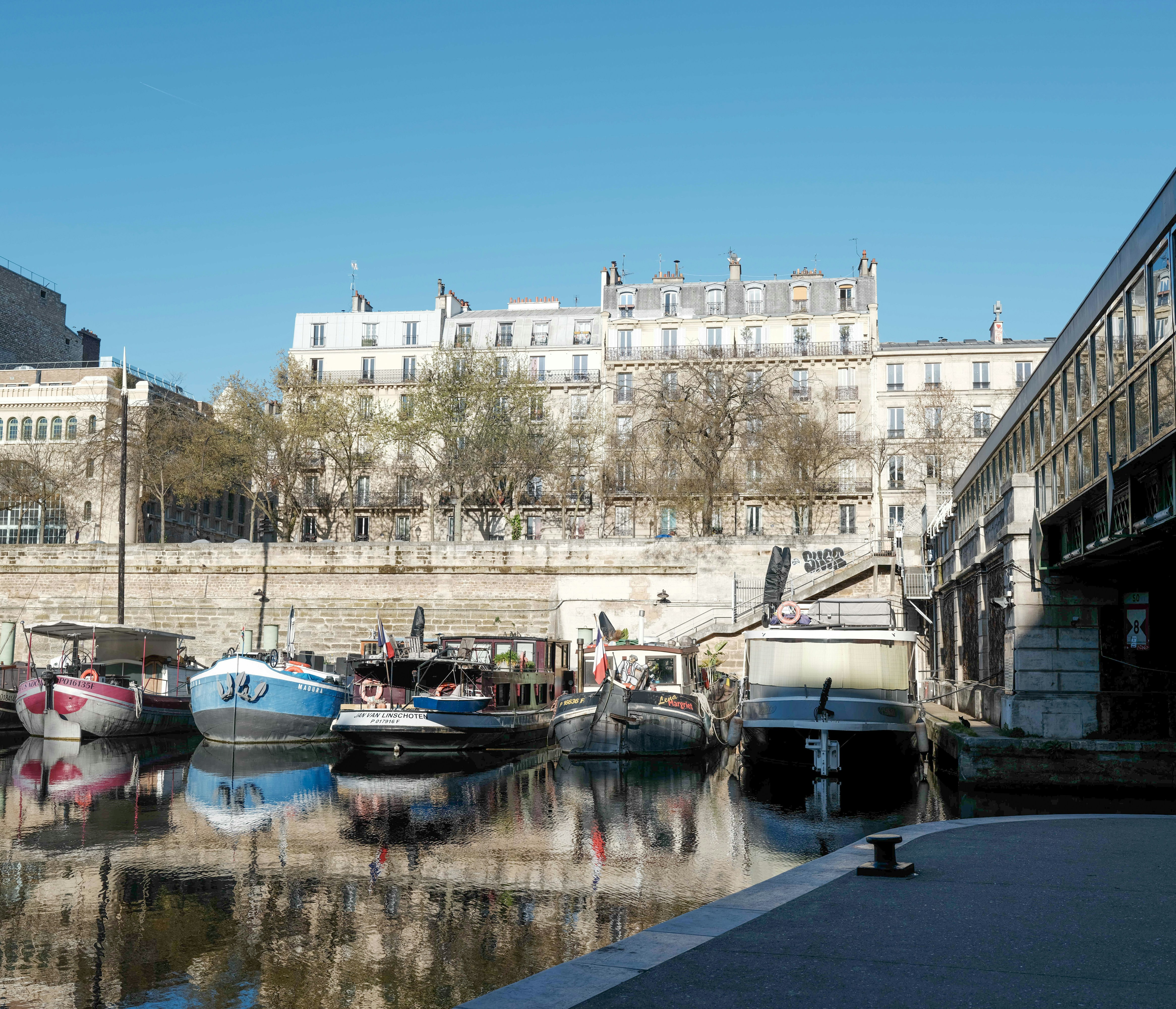 Waterfront Barques and Haussmannian Facades Reflected in a Calm Canal