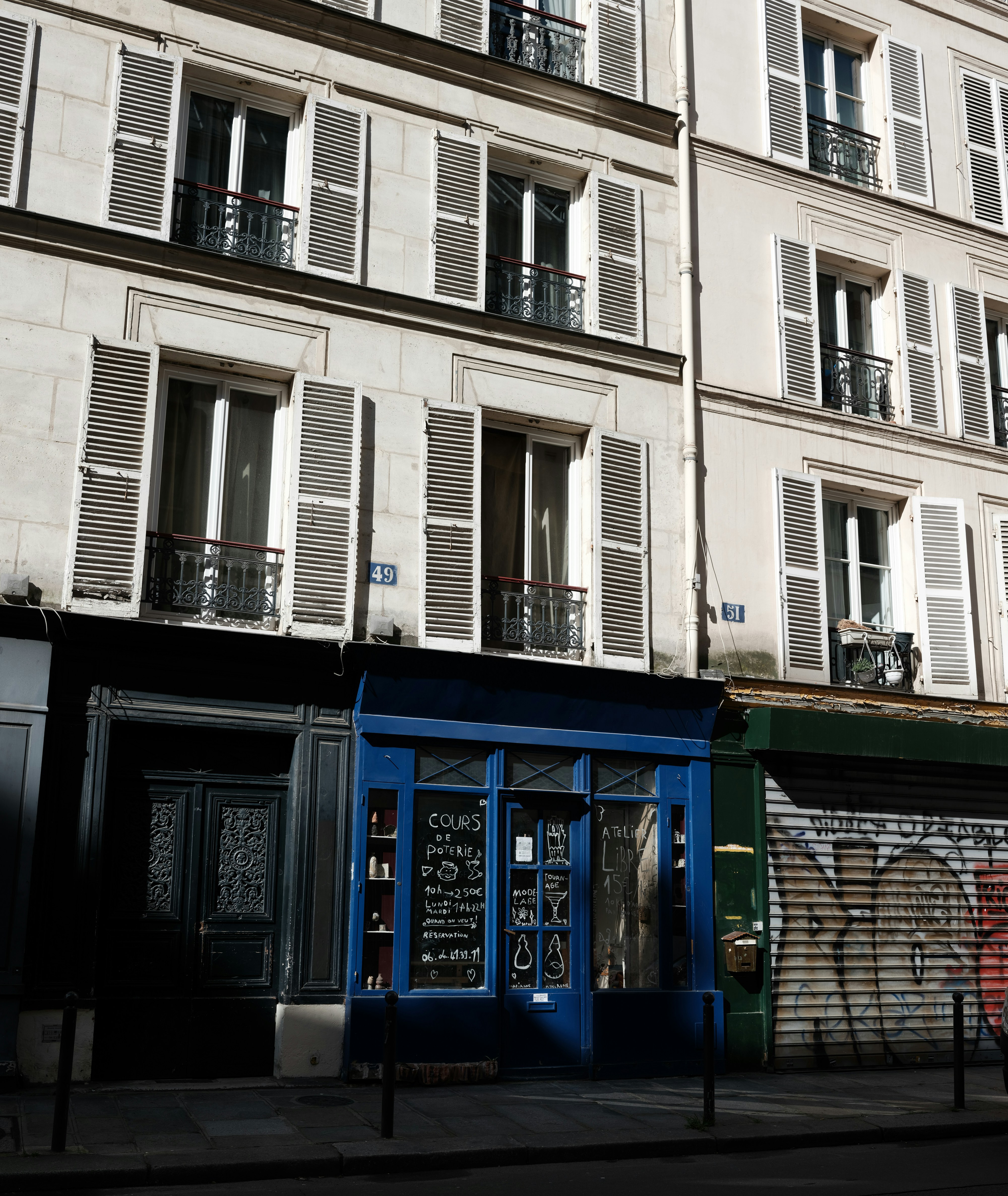 Blue storefront under Parisian facade