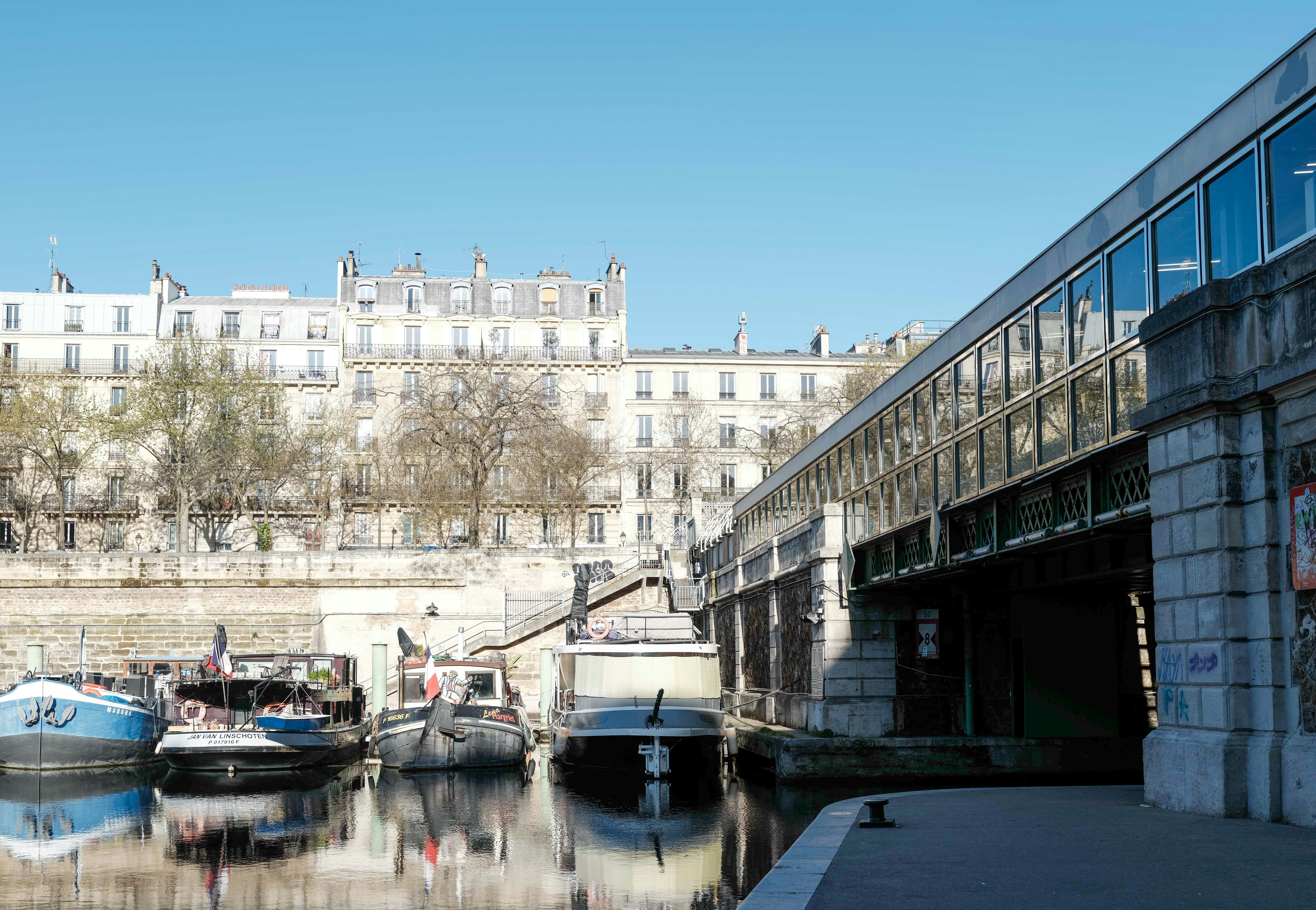 Blue Sky over the Seine: Boats, Bridge, and Historic Facades