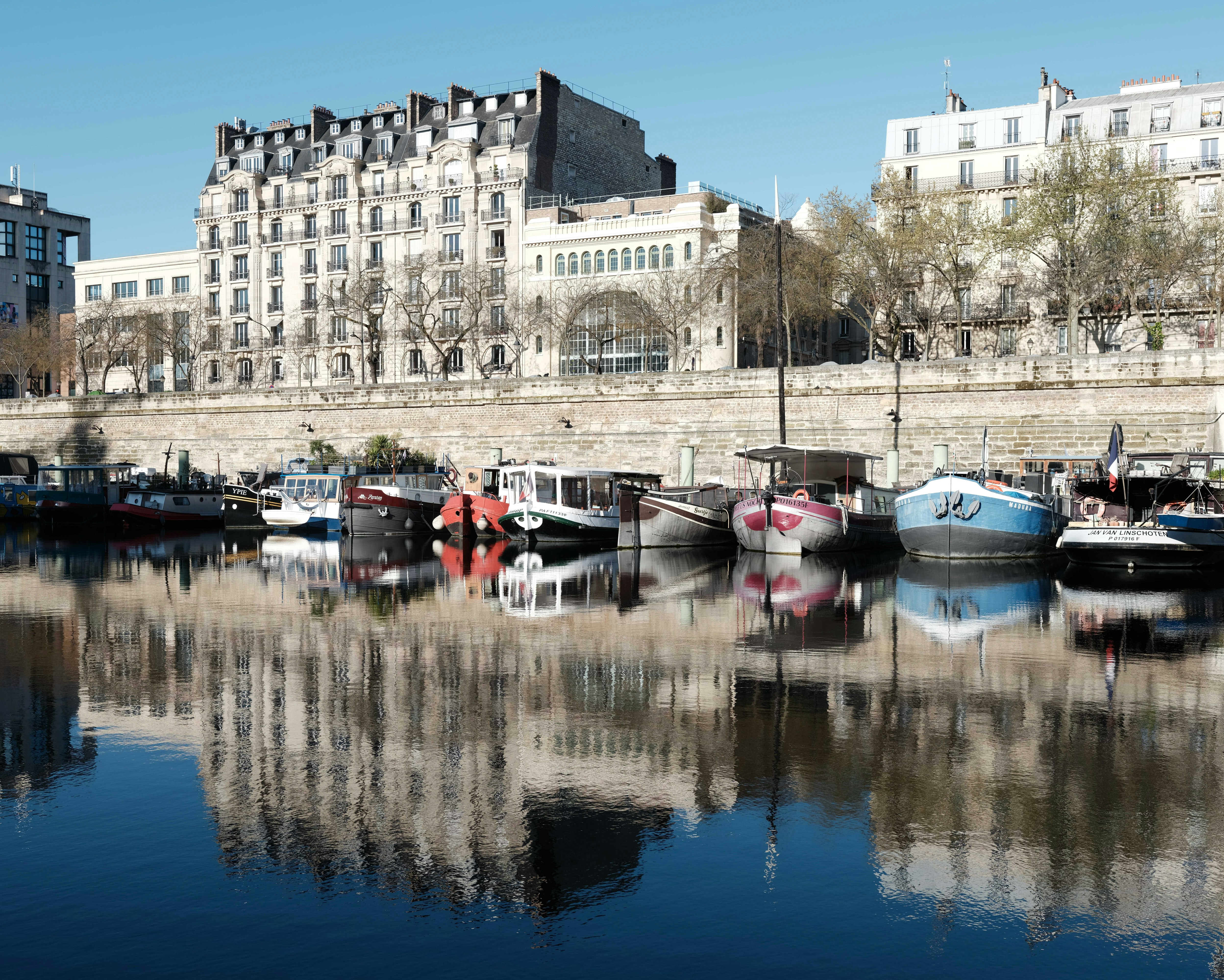 Harborfront Reflections: Boats and Historic Buildings Mirror a Calm Skyline