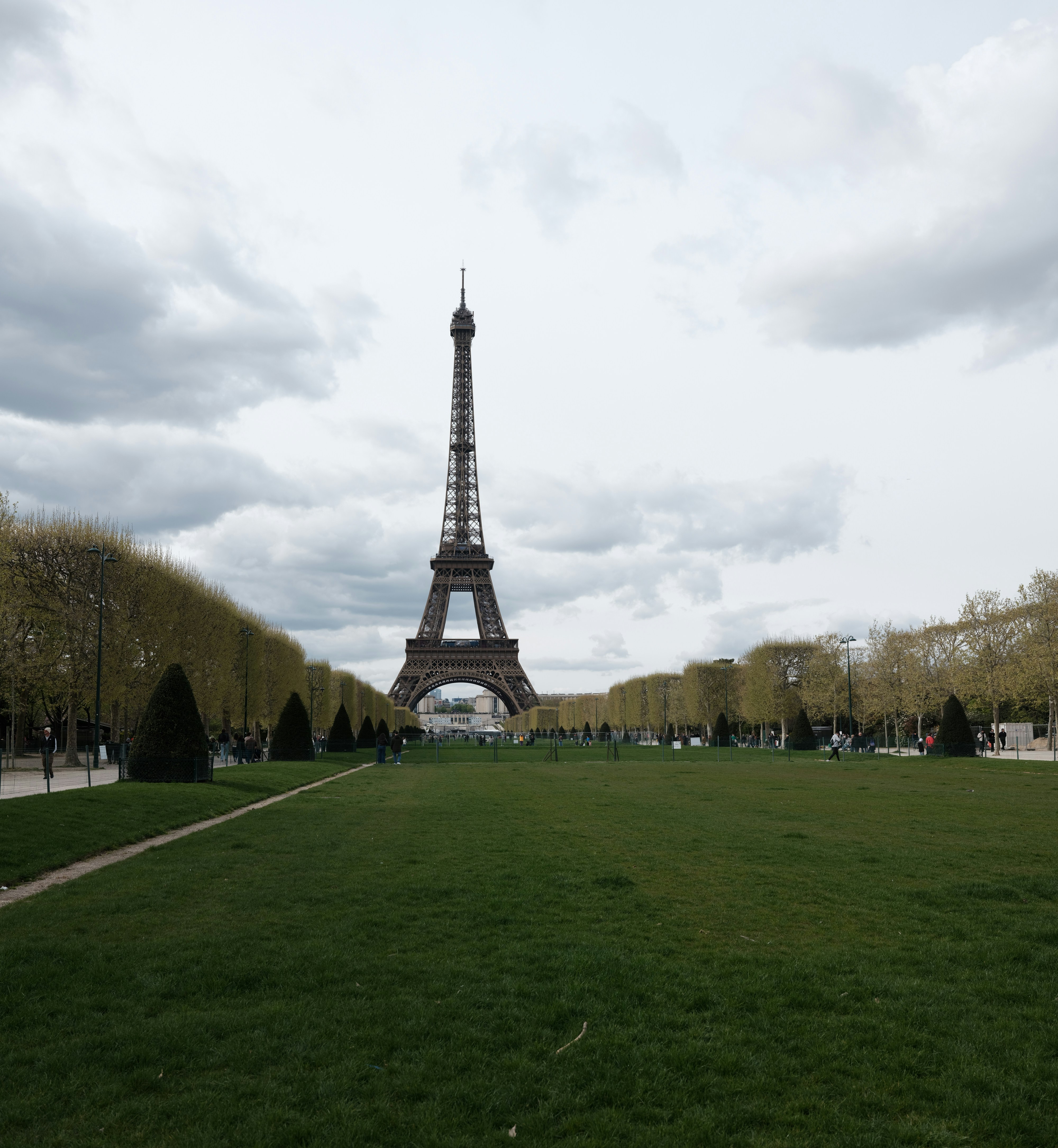 Midway under the Parisian Clock: The Eiffel Tower Framed by Aligned Alleys