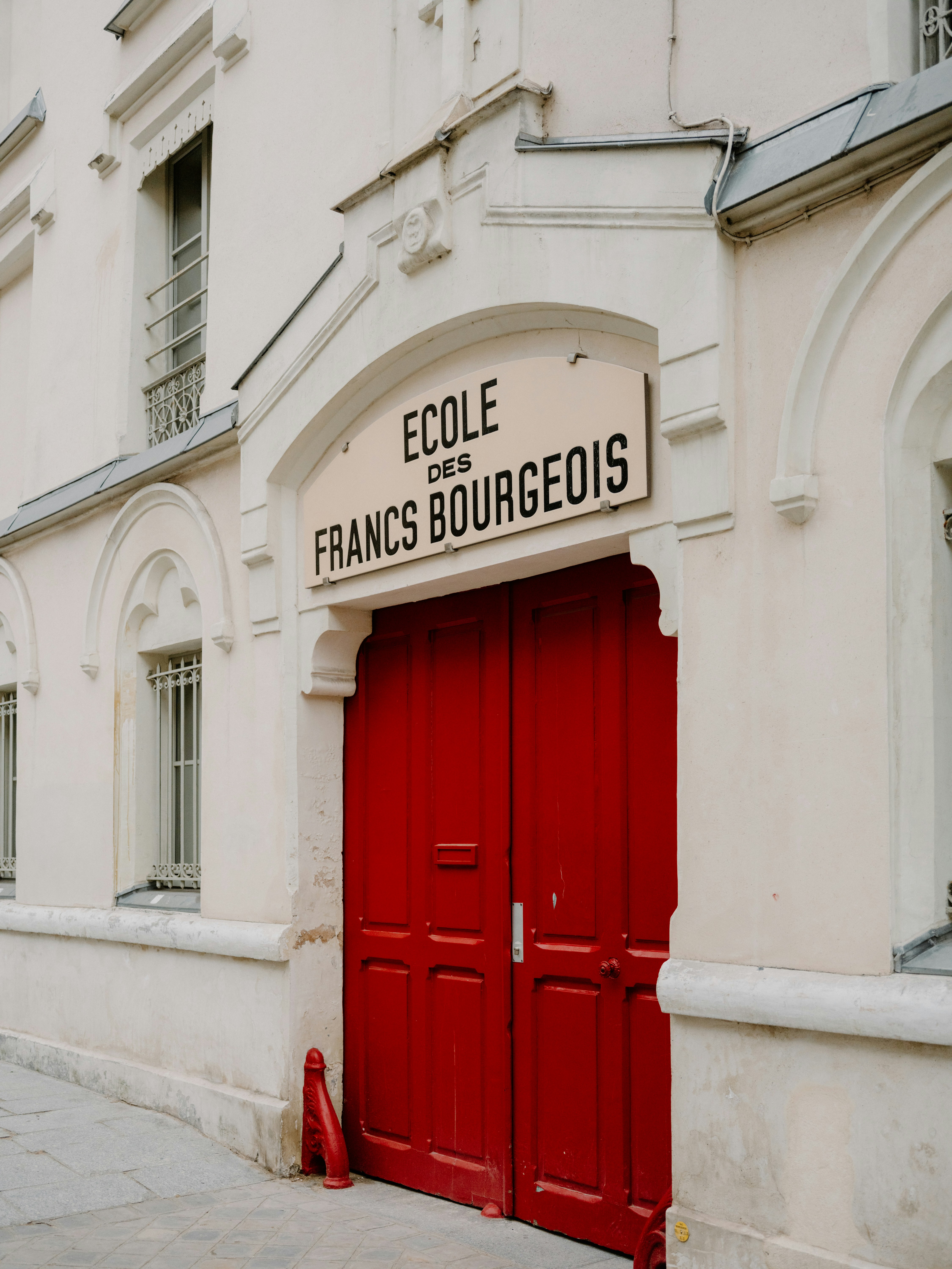 Crimson Doors of the School: A Parisian Facade in Soft Light