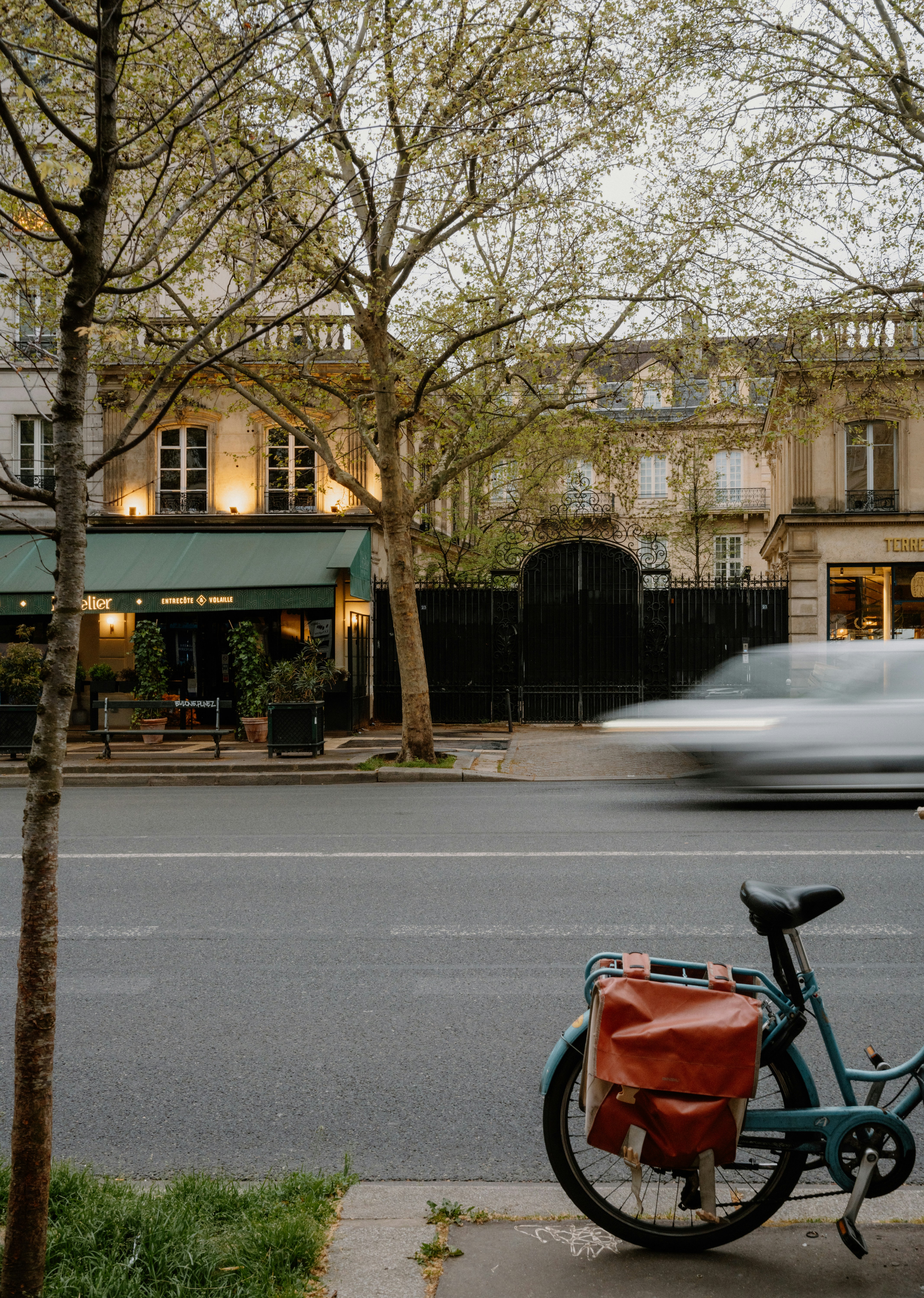 Parisian Street Scene: A Teal Bicycle with Orange Cargo on a Quiet Morning
