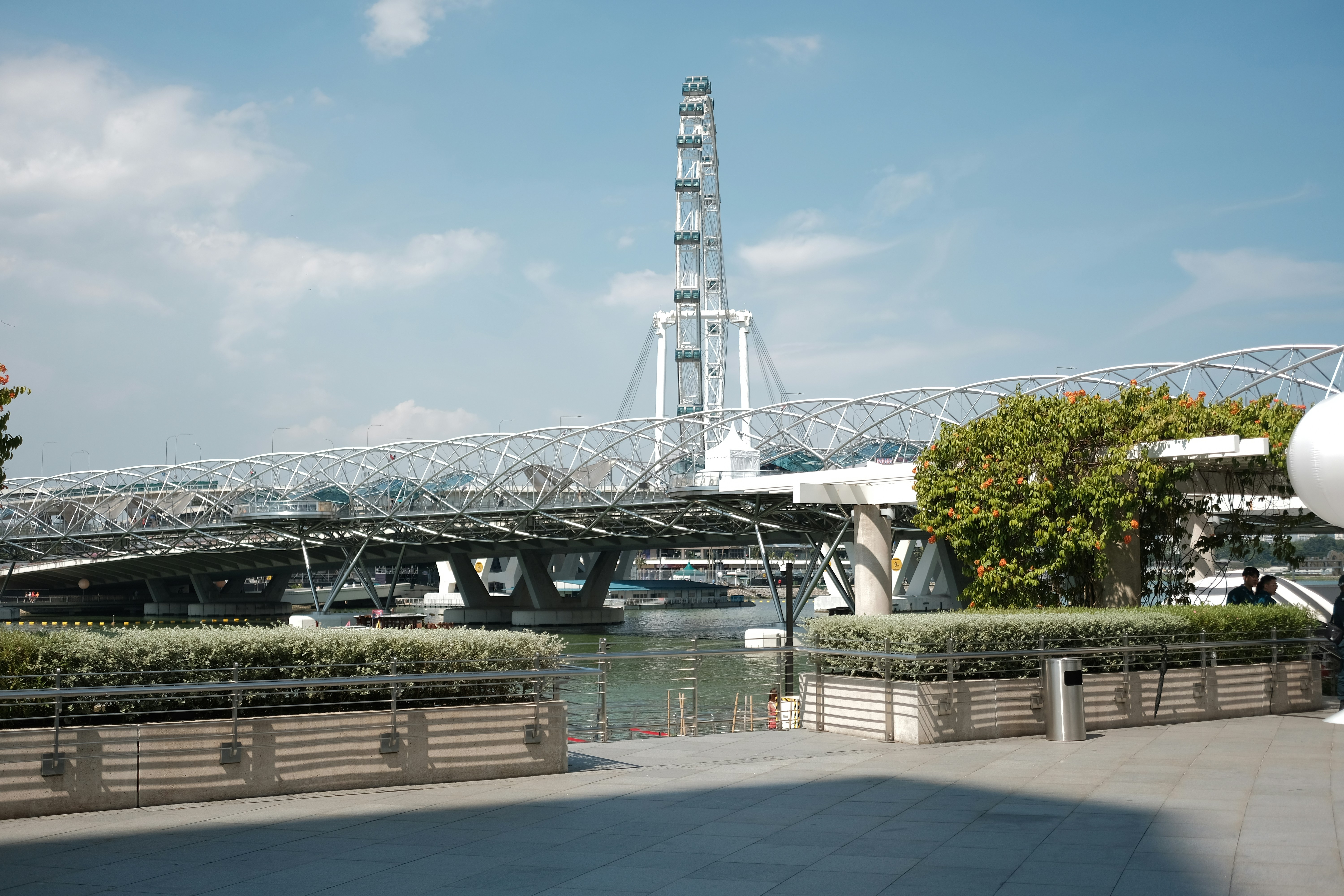 Toward the Ferris Wheel: A riverside view with a modern bridge