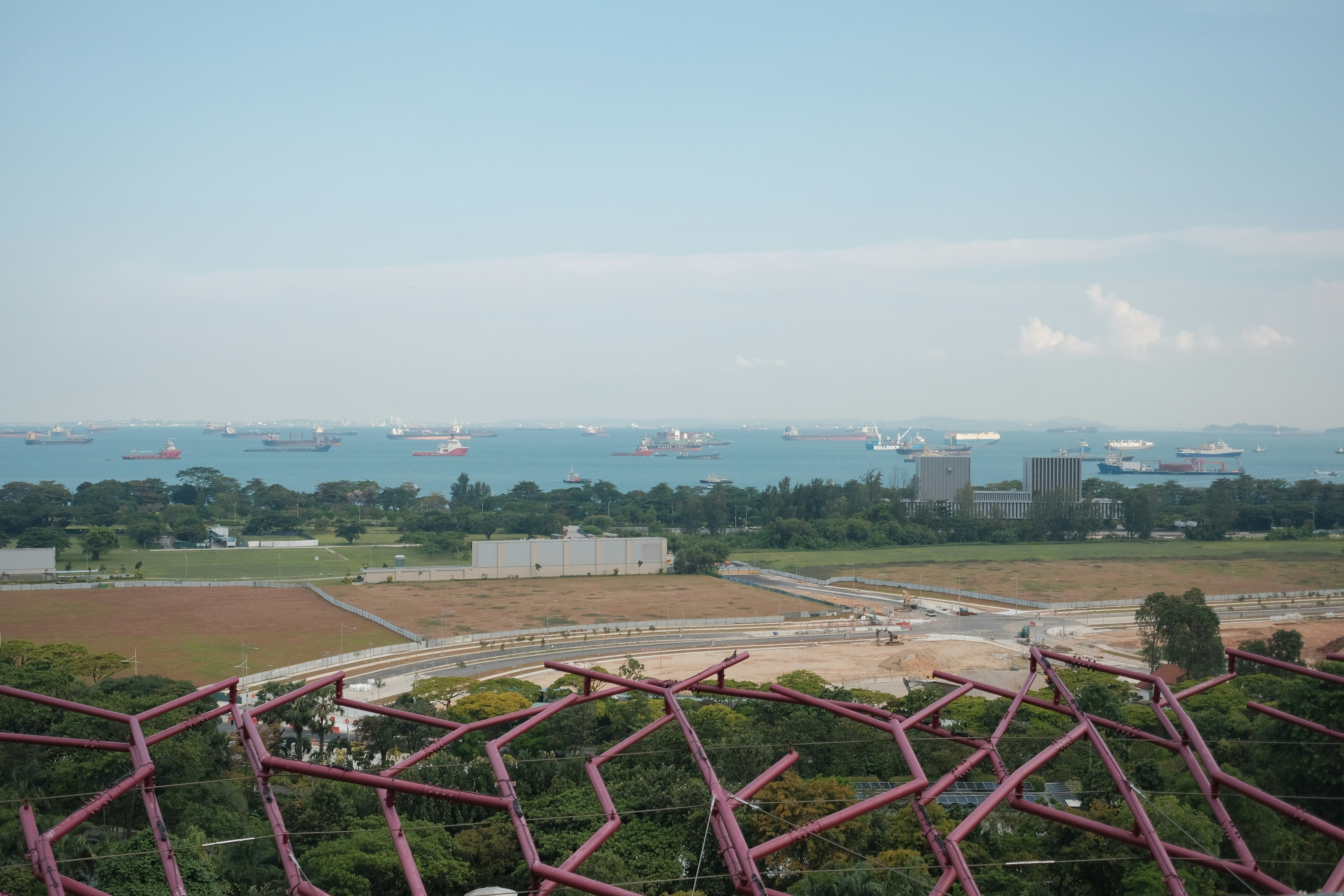 Framed Harbor Vista Behind a Geometric Mint–Pink Barrier