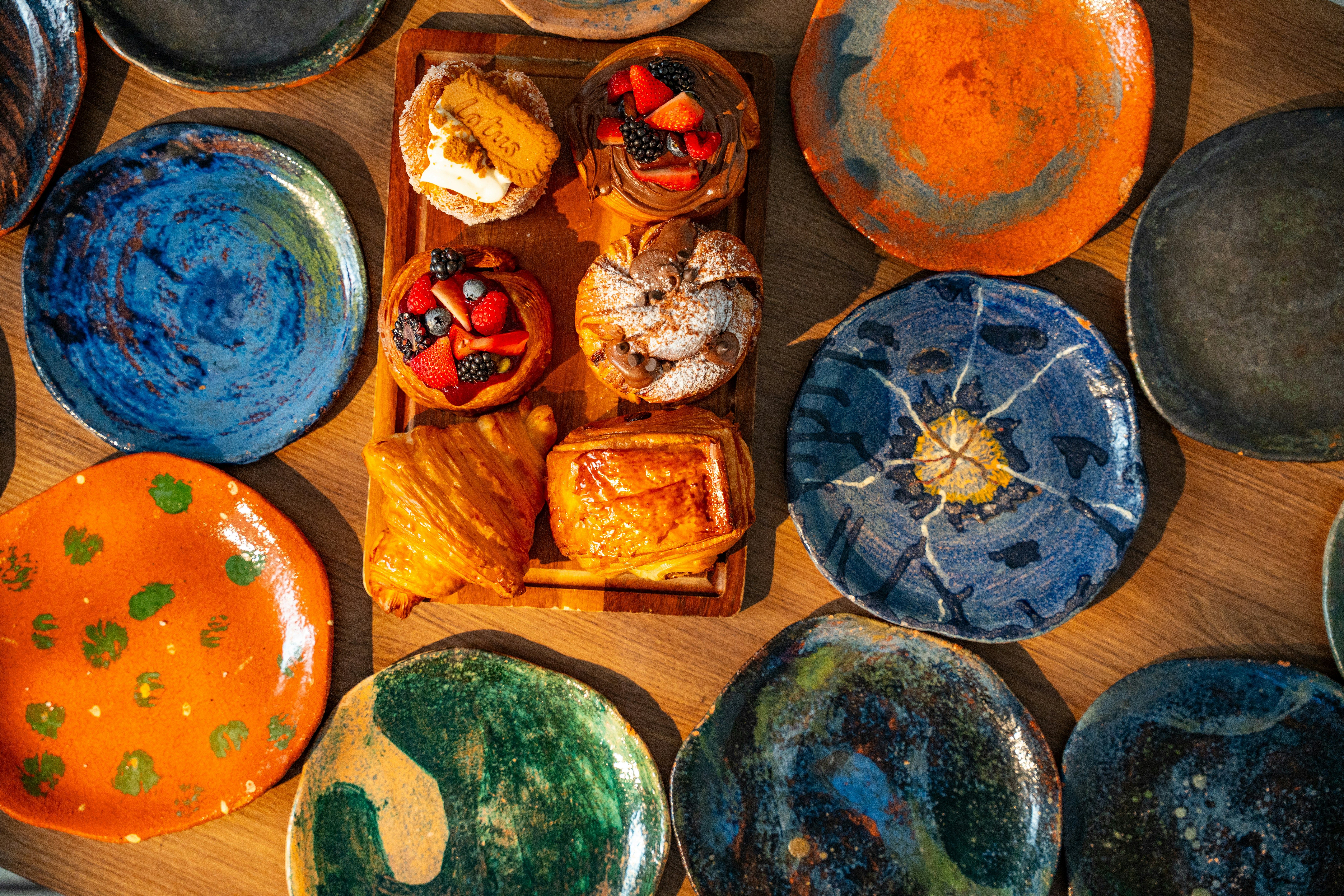 Assorted Ceramic Plates Framing a Pastry-taveled Still Life