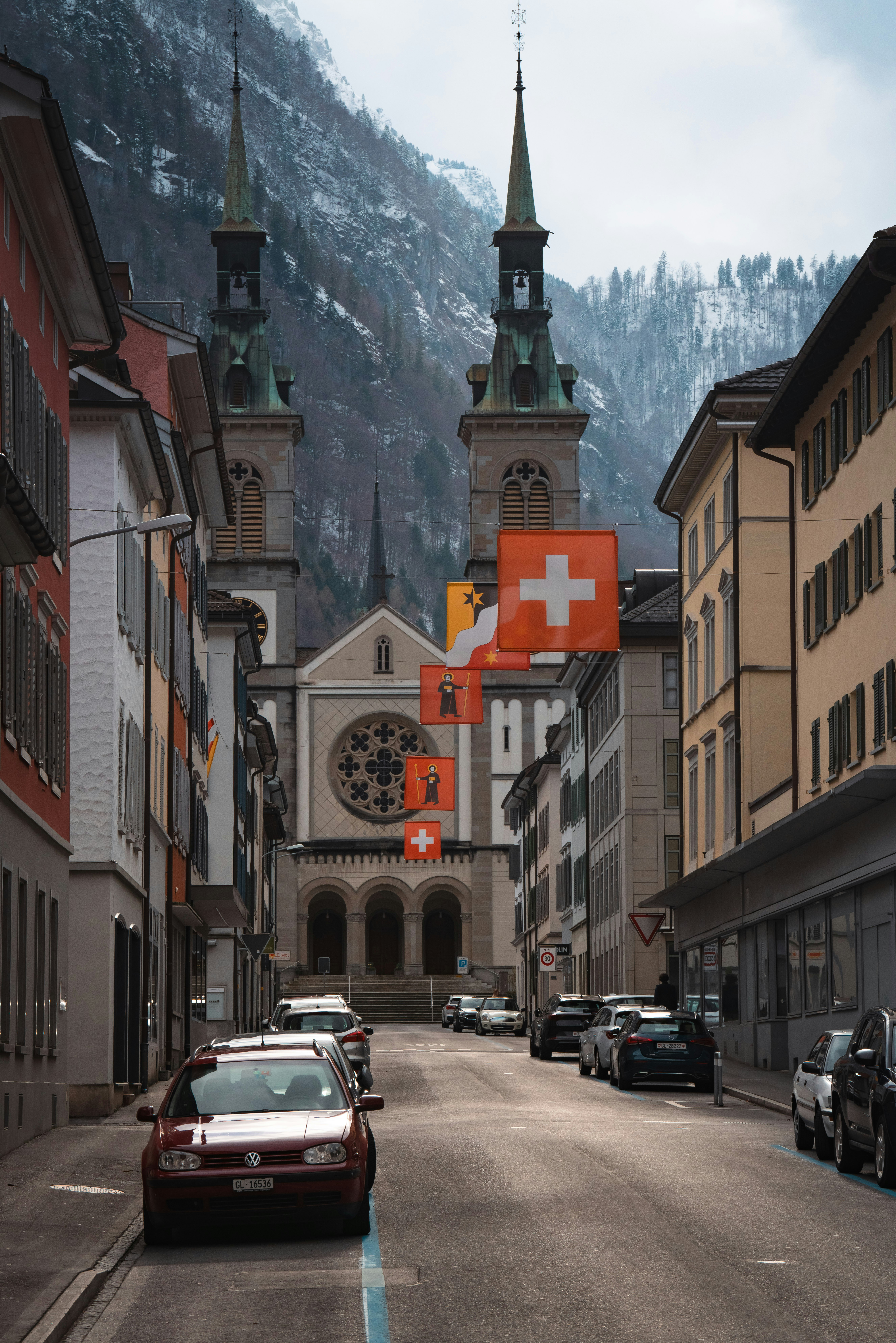 Swiss Flags and Gothic Facade Framed by Alpine Streets