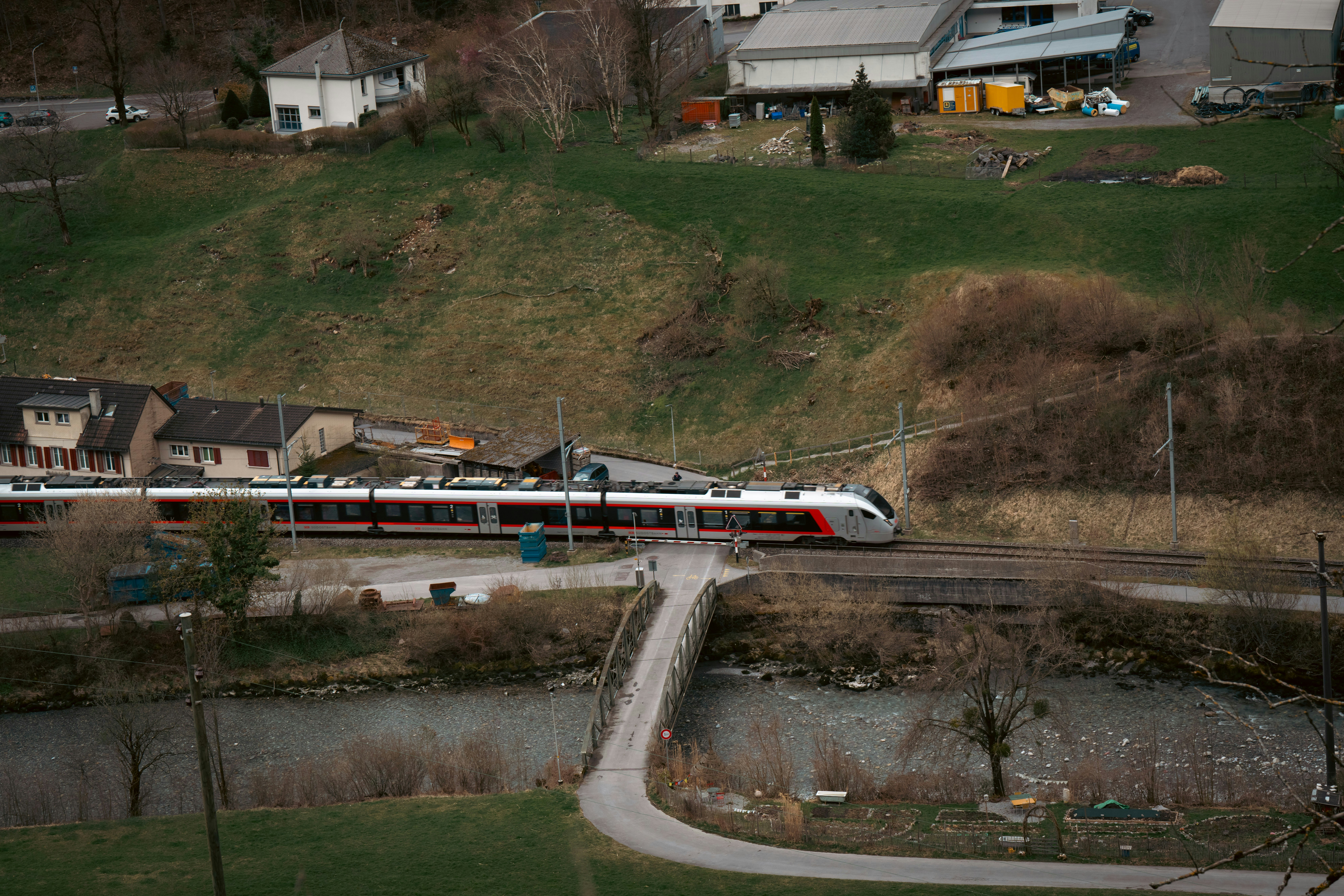 Red Rail Glide: A Passenger Train Crossing a Narrow Bridge