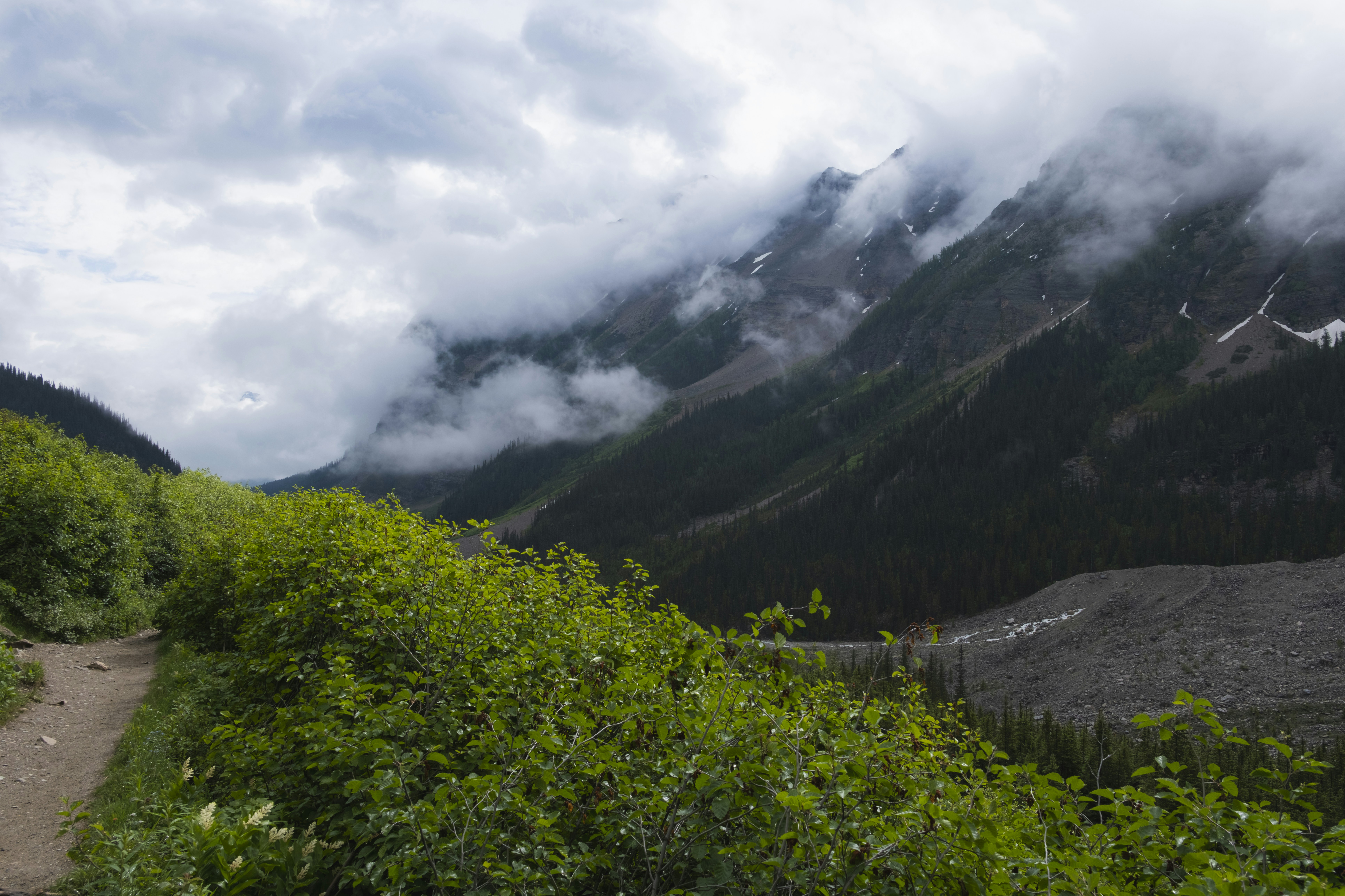 Green ridge under a loom of clouds in a alpine valley