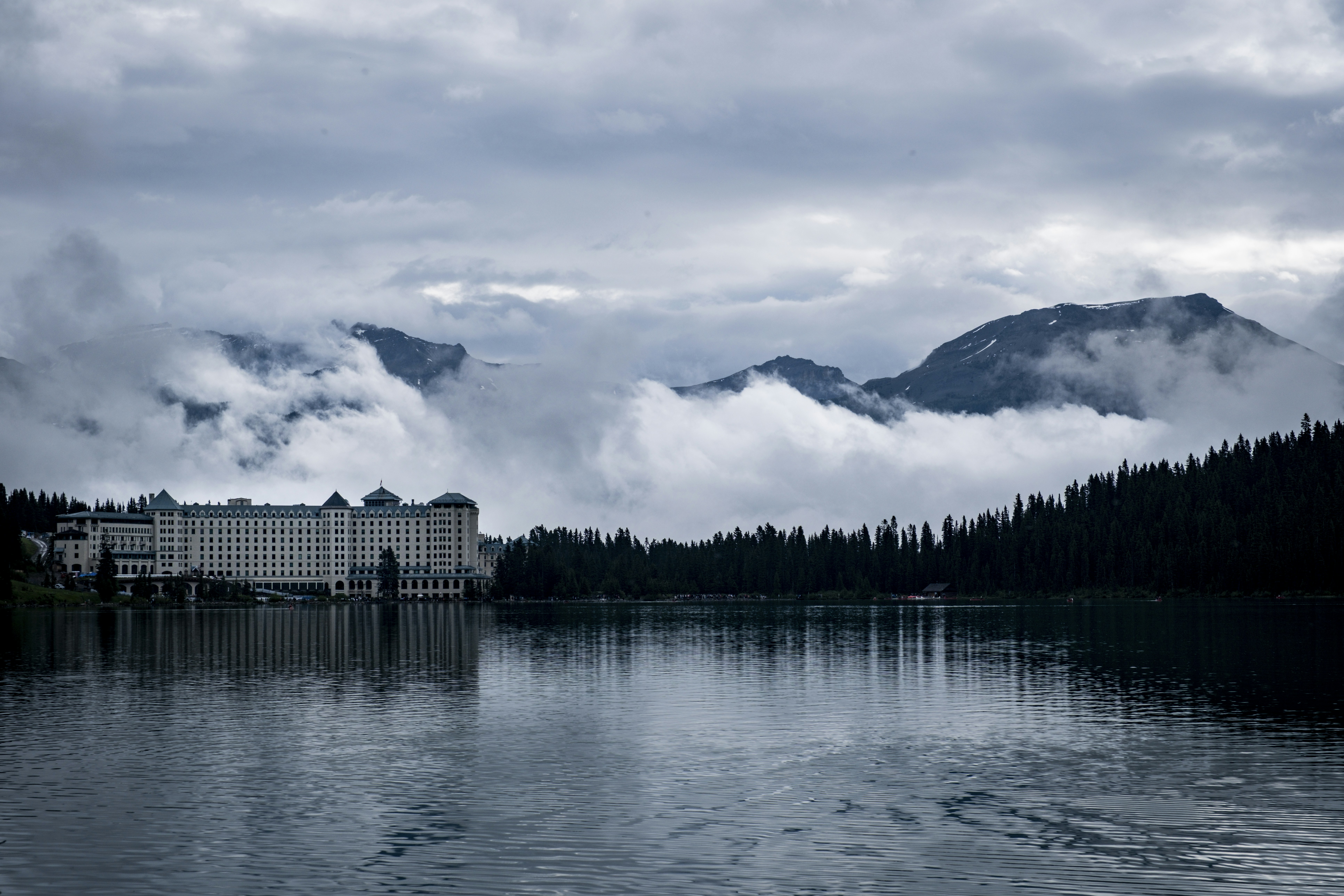 Misty lakeside retreat beneath cloud-wreathed peaks