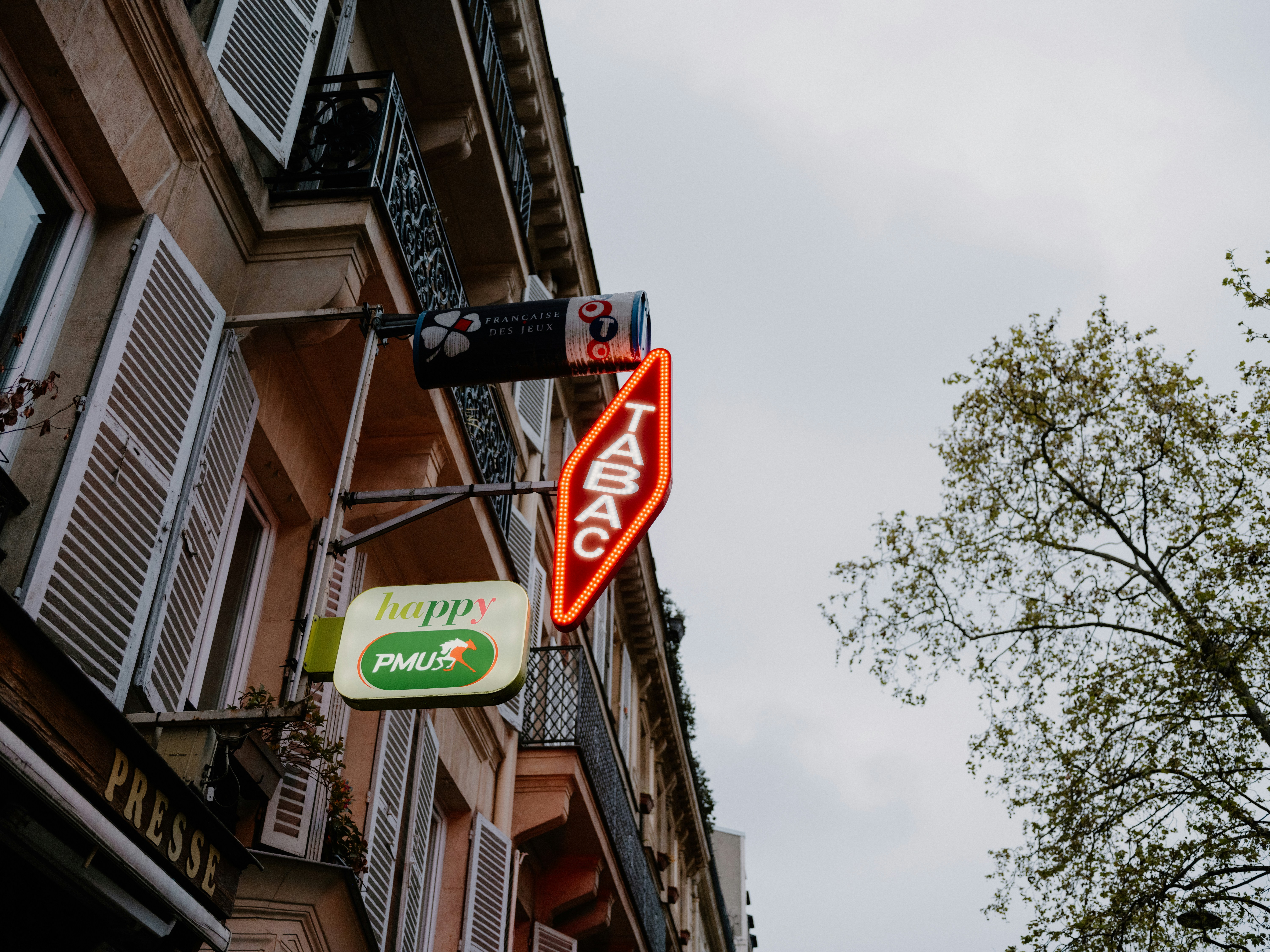 Neon Signage on a Parisian Facade Above a Quiet Street