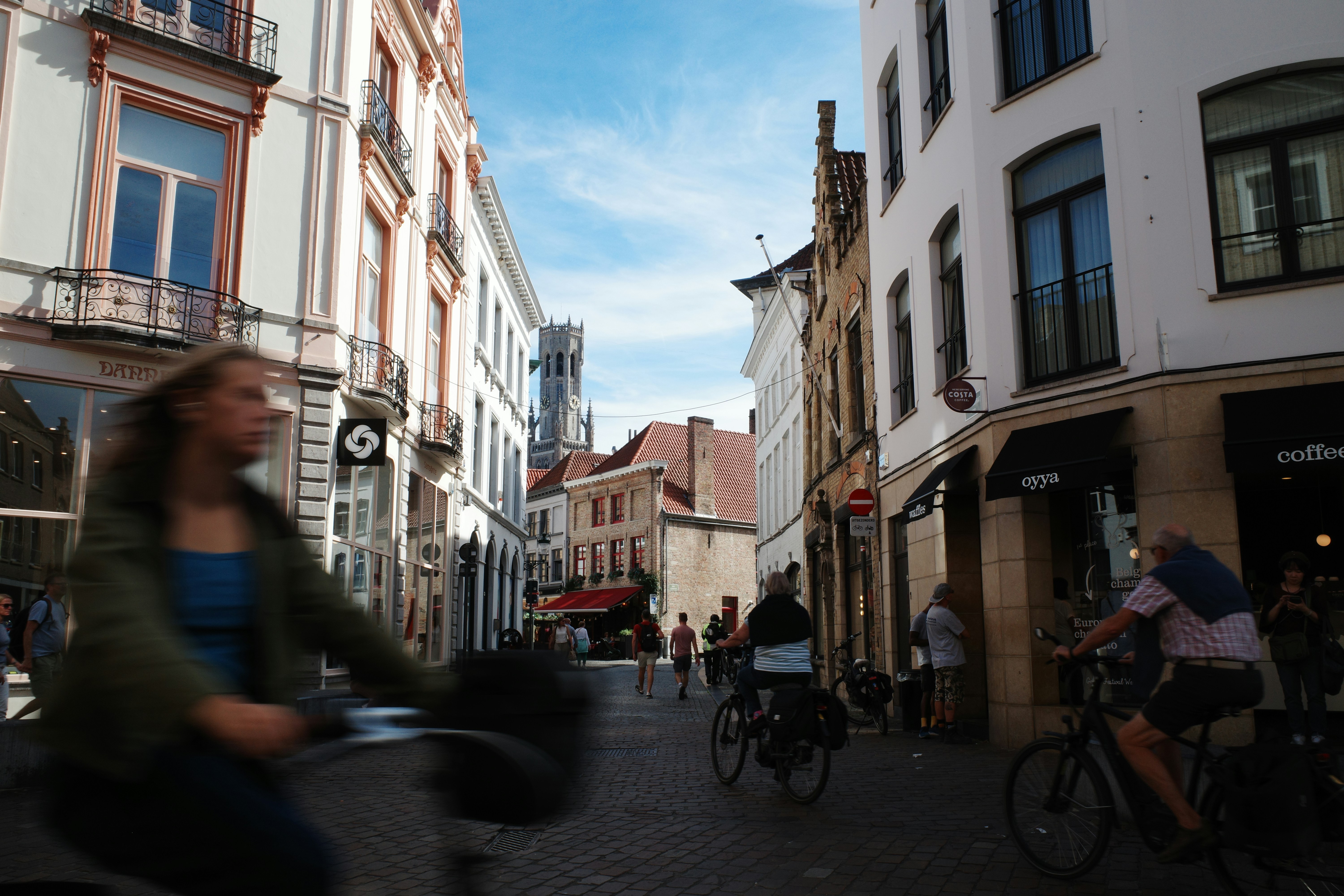 Cobbled Street Pulse: Bikes, Pedestrians, and Historic Facades