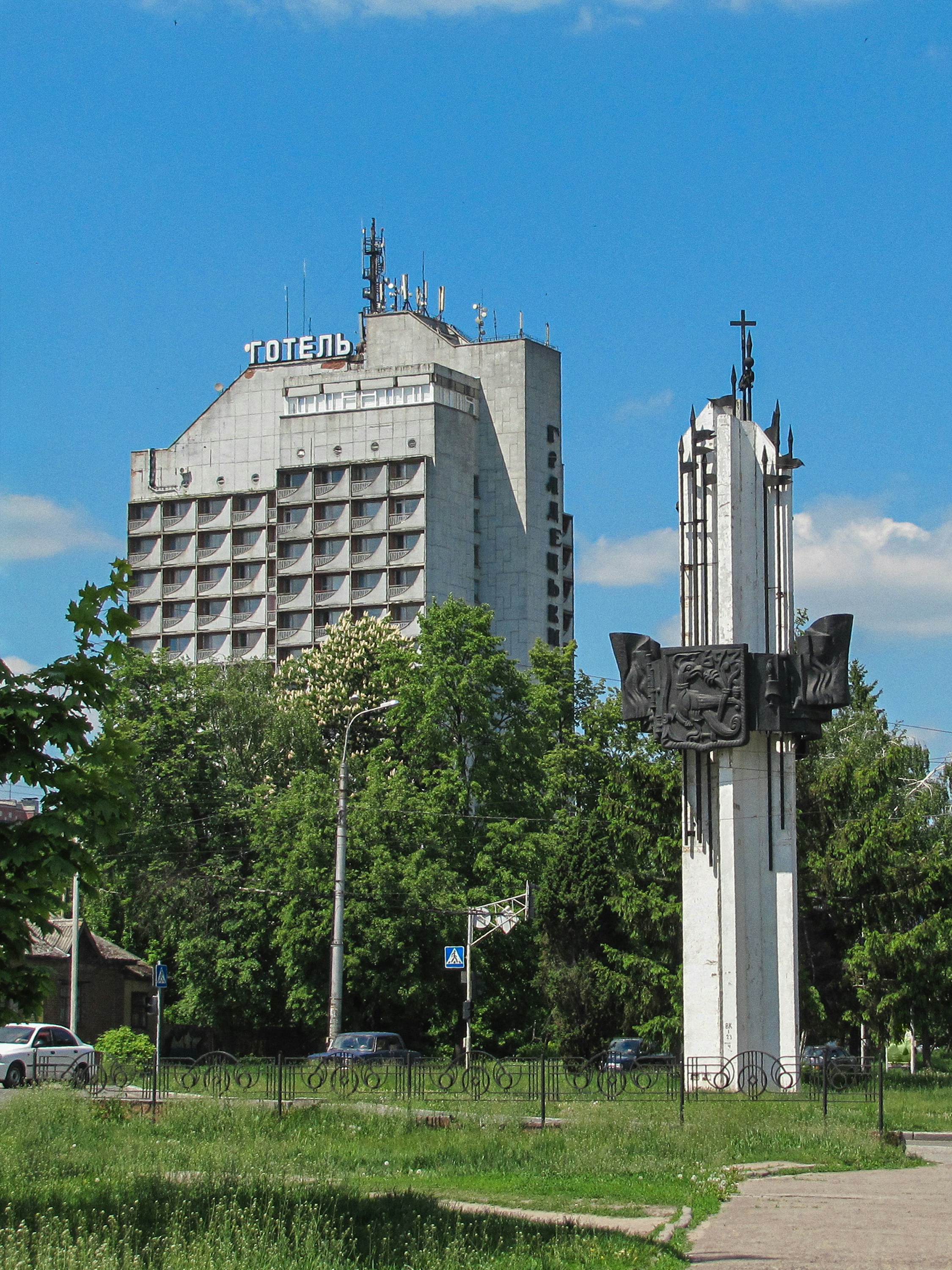 Monument and Skyscraper Rise Over a Tree-Lined Plaza