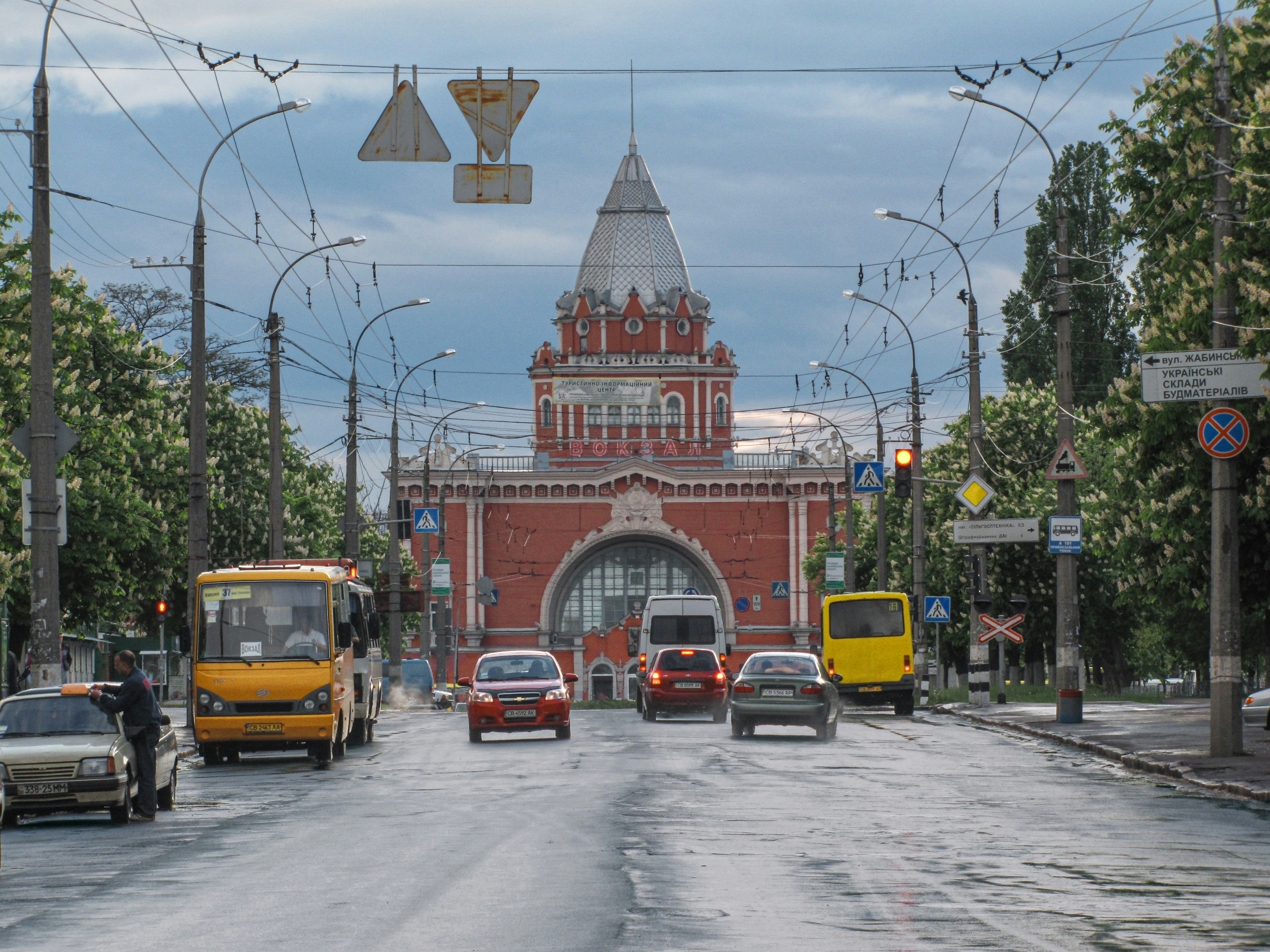 Gatehouse Boulevard: Red Archway Amid a Rain-Slick City Street