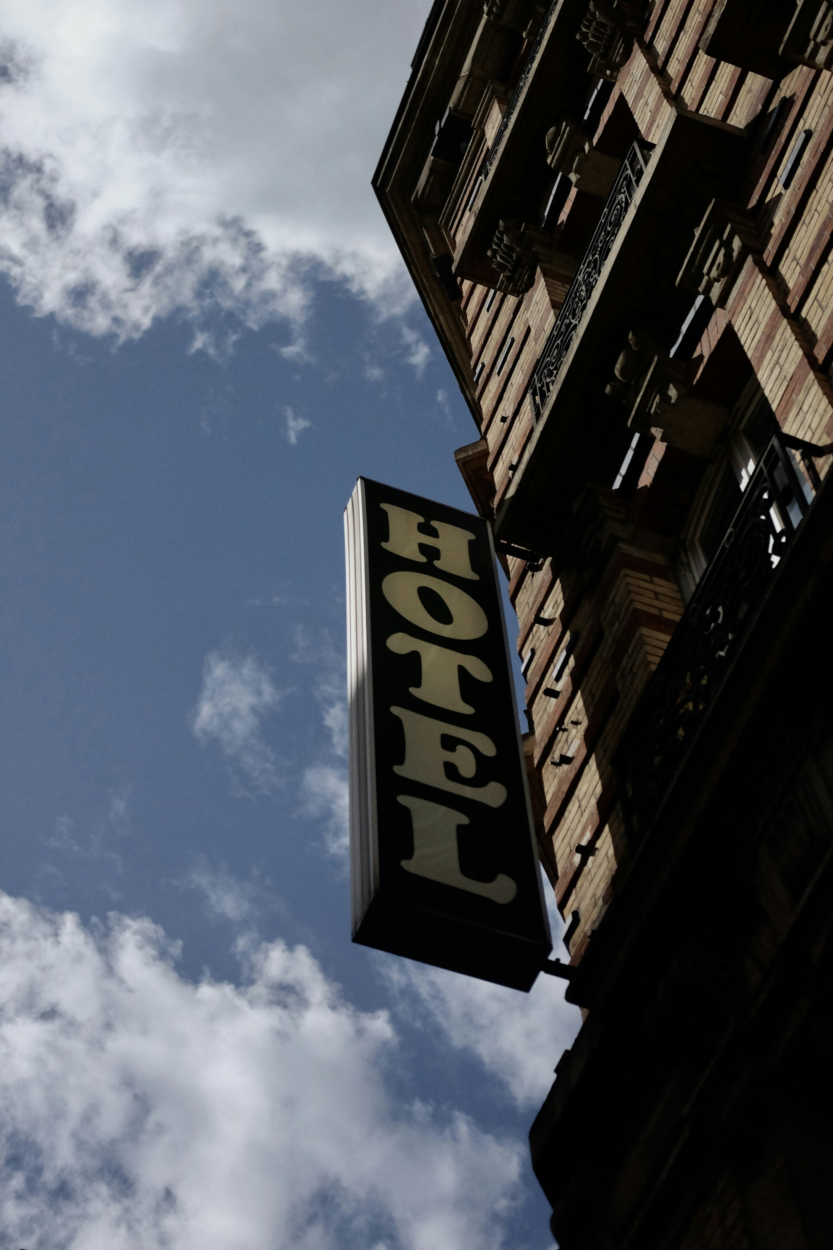 Vertical Sign, Horizontal City: A Neon Hotel Sign Reaching Toward the Sky