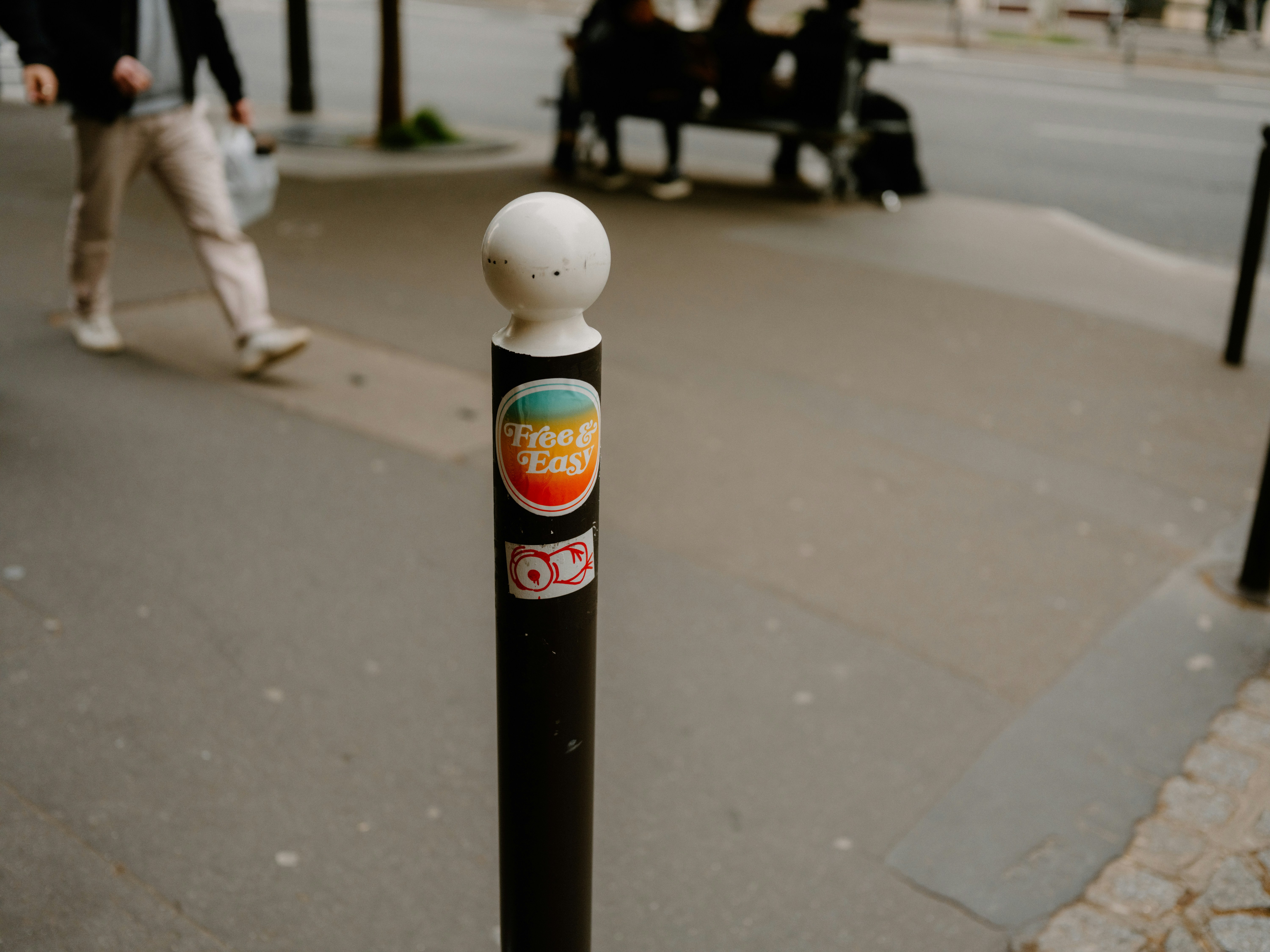 Pole with Free Bask sticker on a quiet city sidewalk