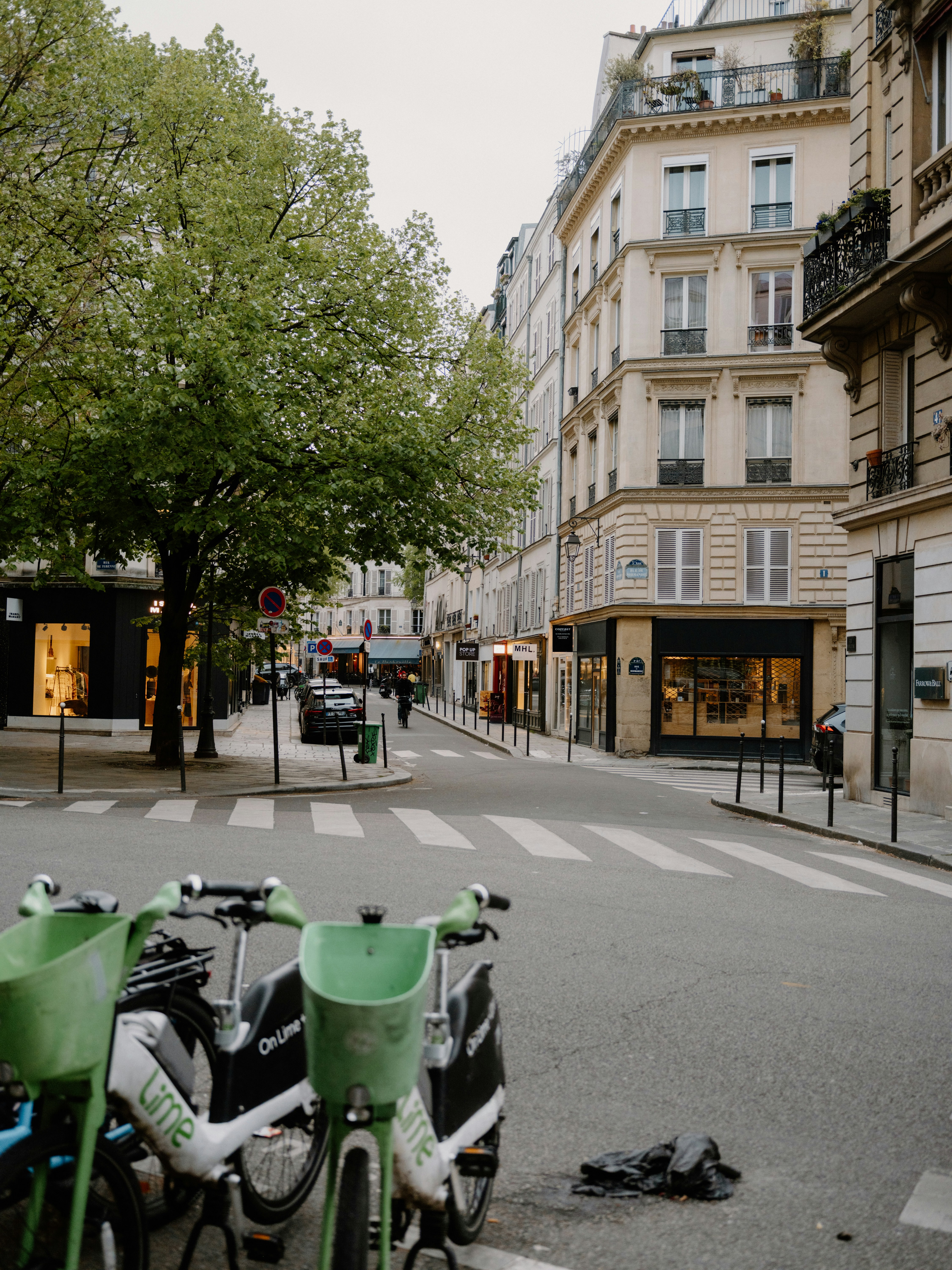 Parisian Street at Dusk: Bicycles, Crosswalks, and a Quiet Facade