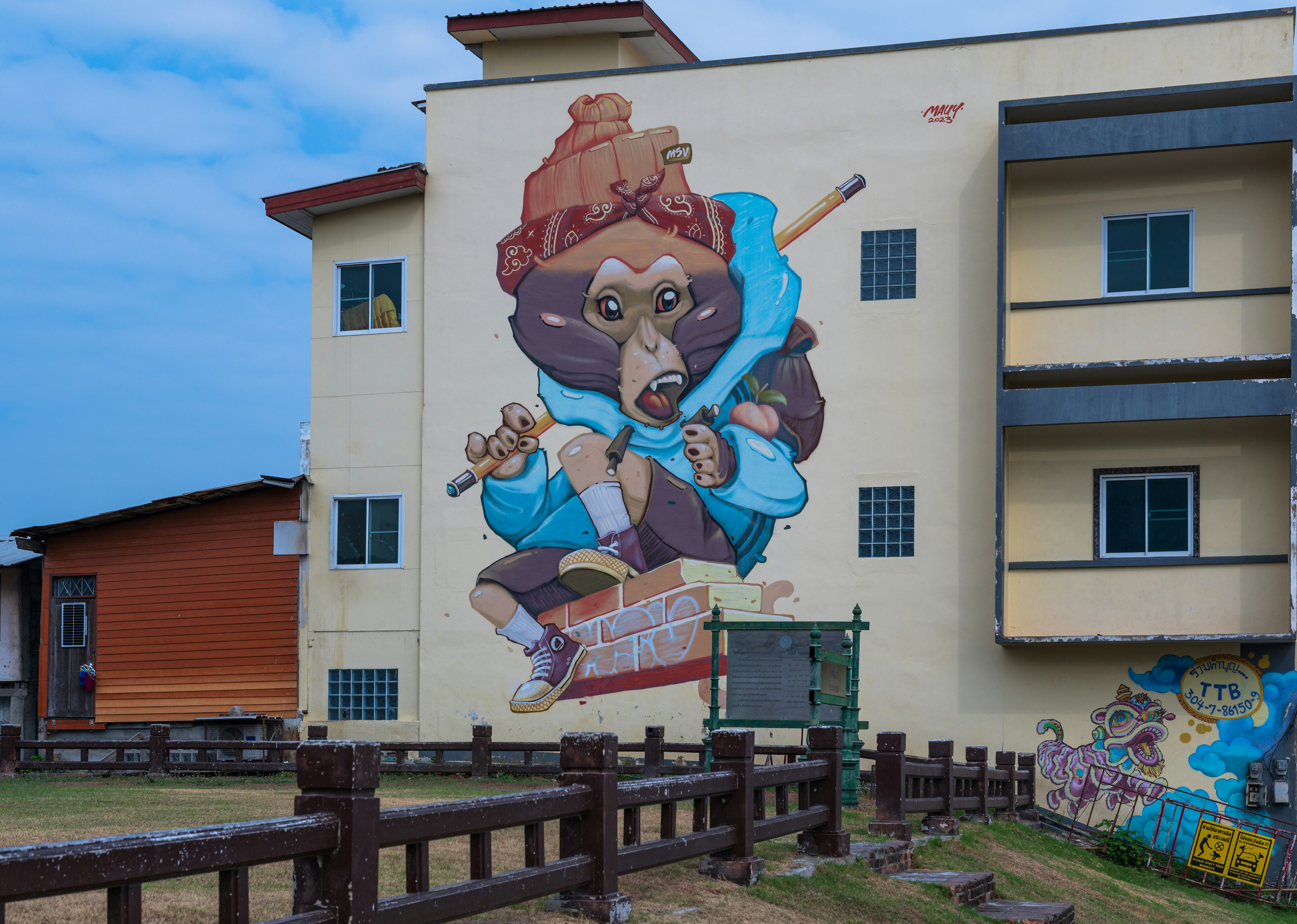 Graffiti Giant: Monkey in a Hoodie Reaches Across the Wall