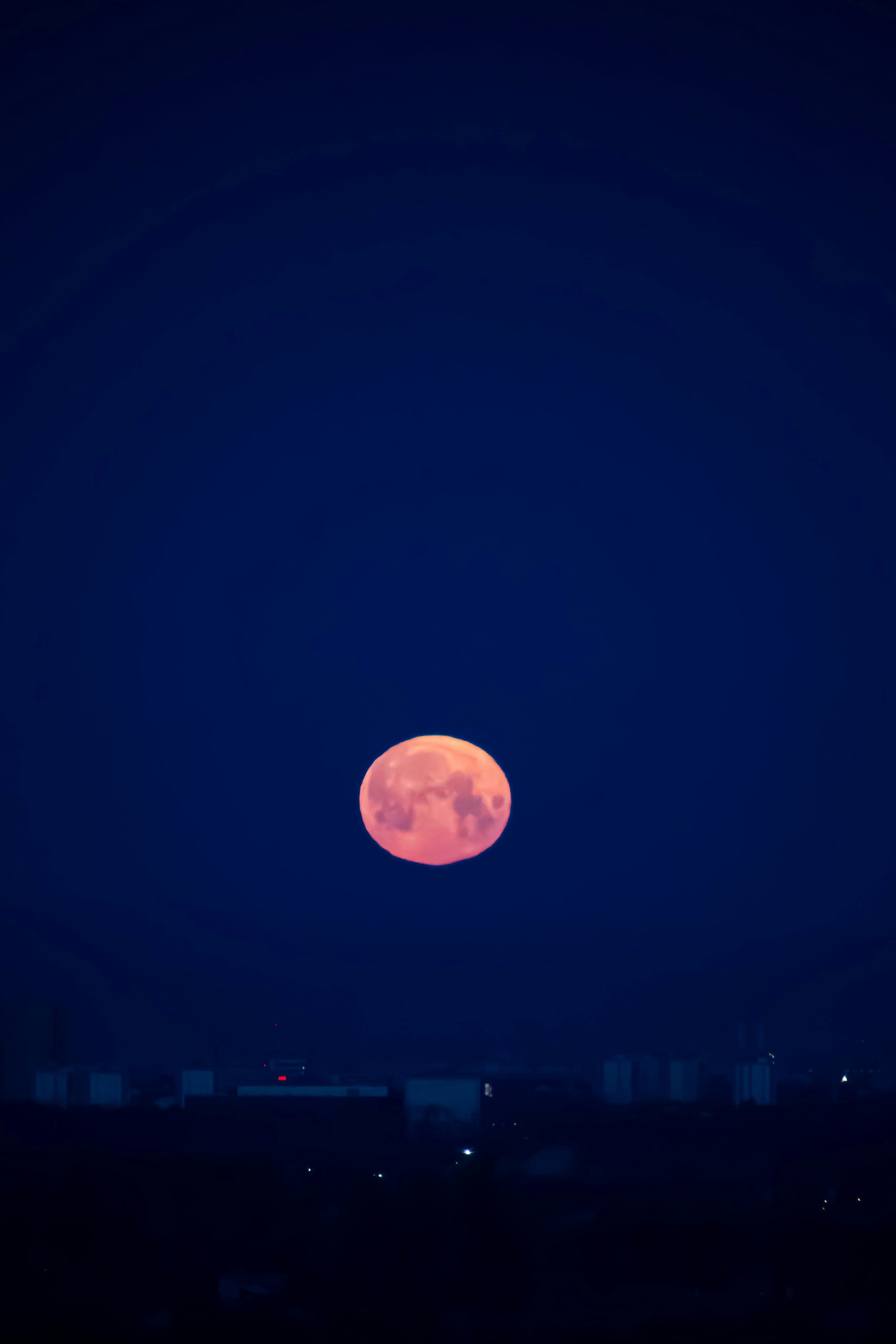 Crimson Moon Over a Quiet Cityscape