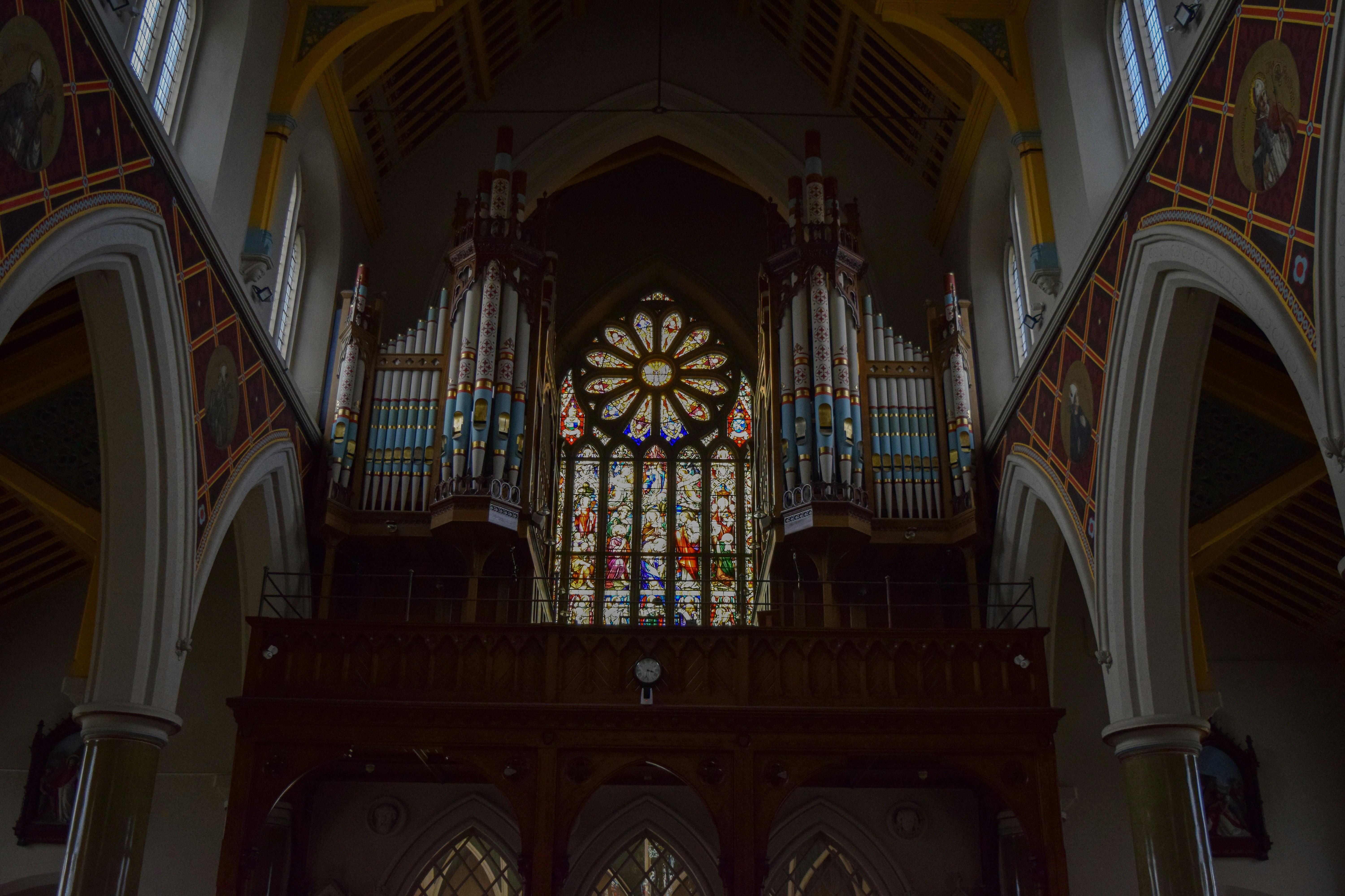 Stained Glass Cathedral: Symmetry and Organ Loft in Gothic Revival Interior