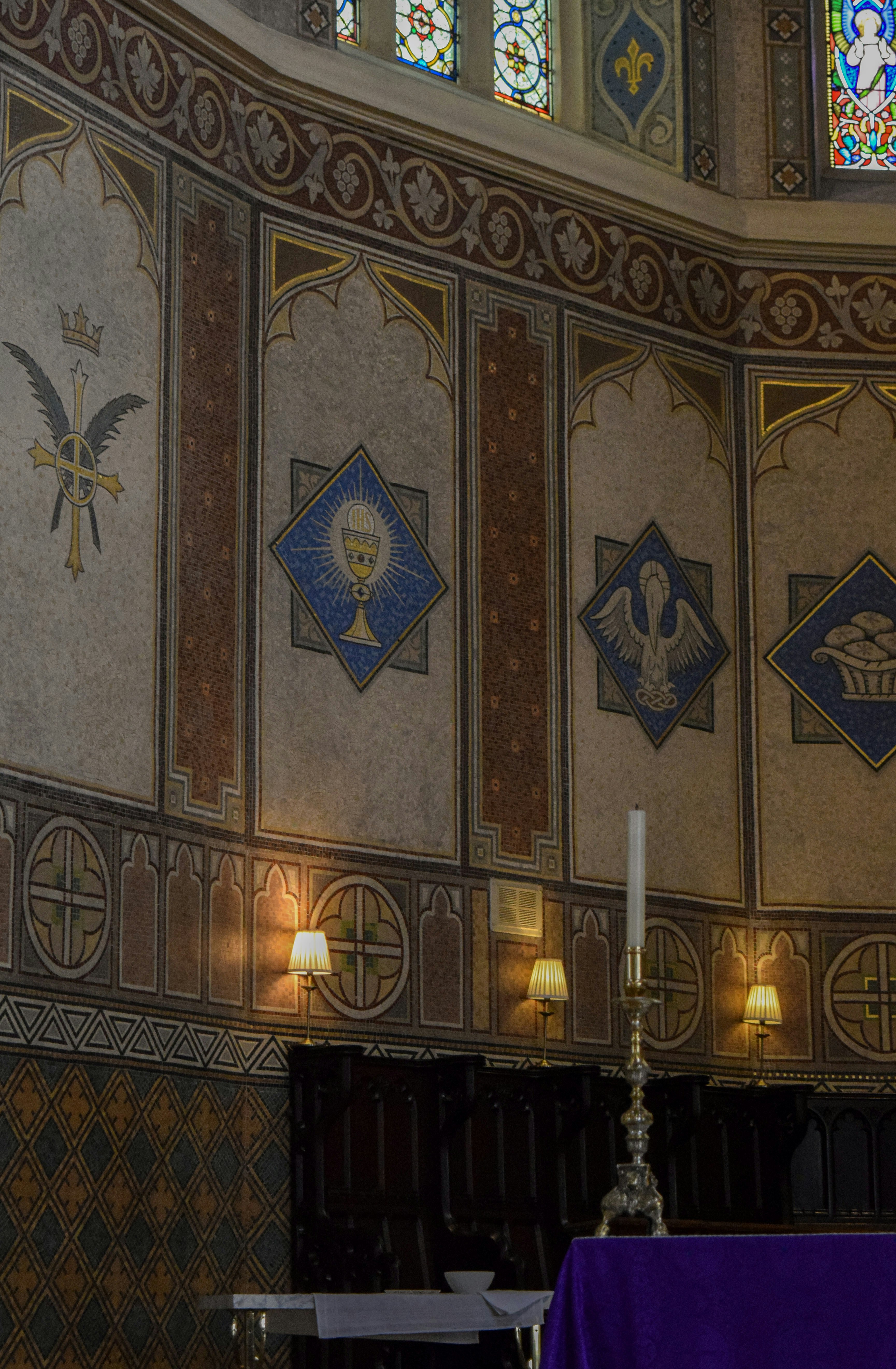 Candlelit altar under medieval frescoes