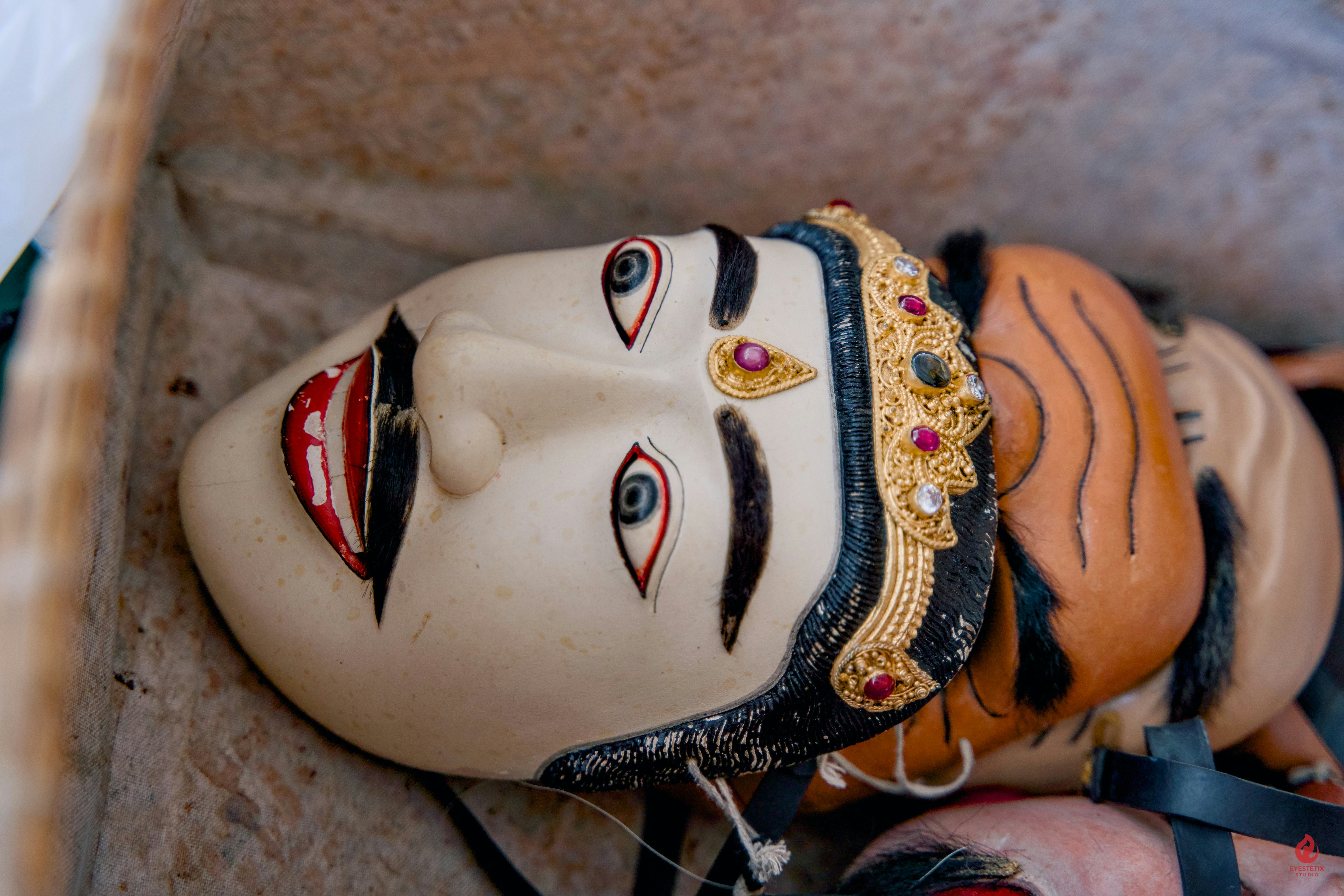 Ceremonial Mask on its Side: A Decorative Face with Jewel-Topped Crown