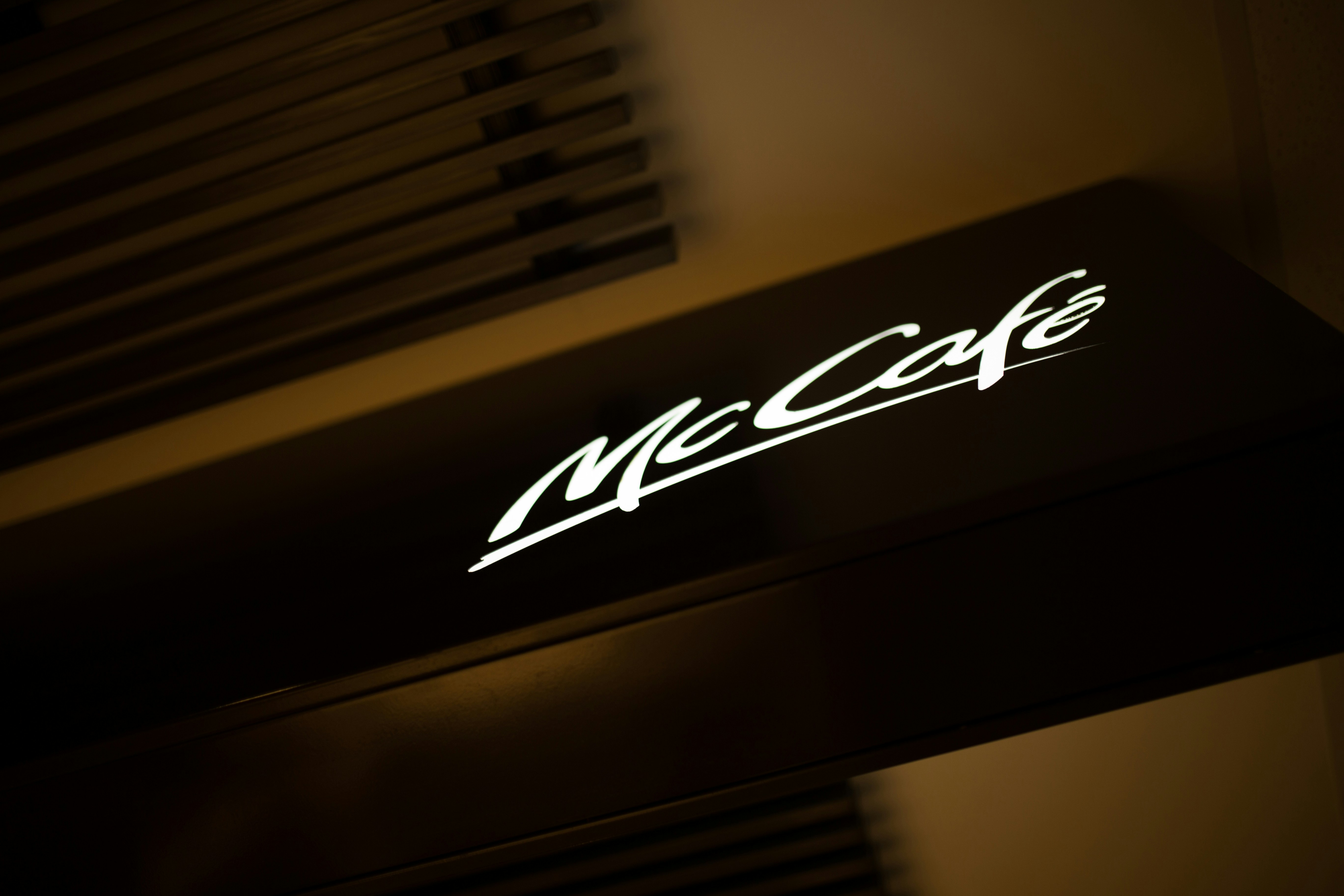 Soft Neon Script: McCafé Logo in Warm Blur