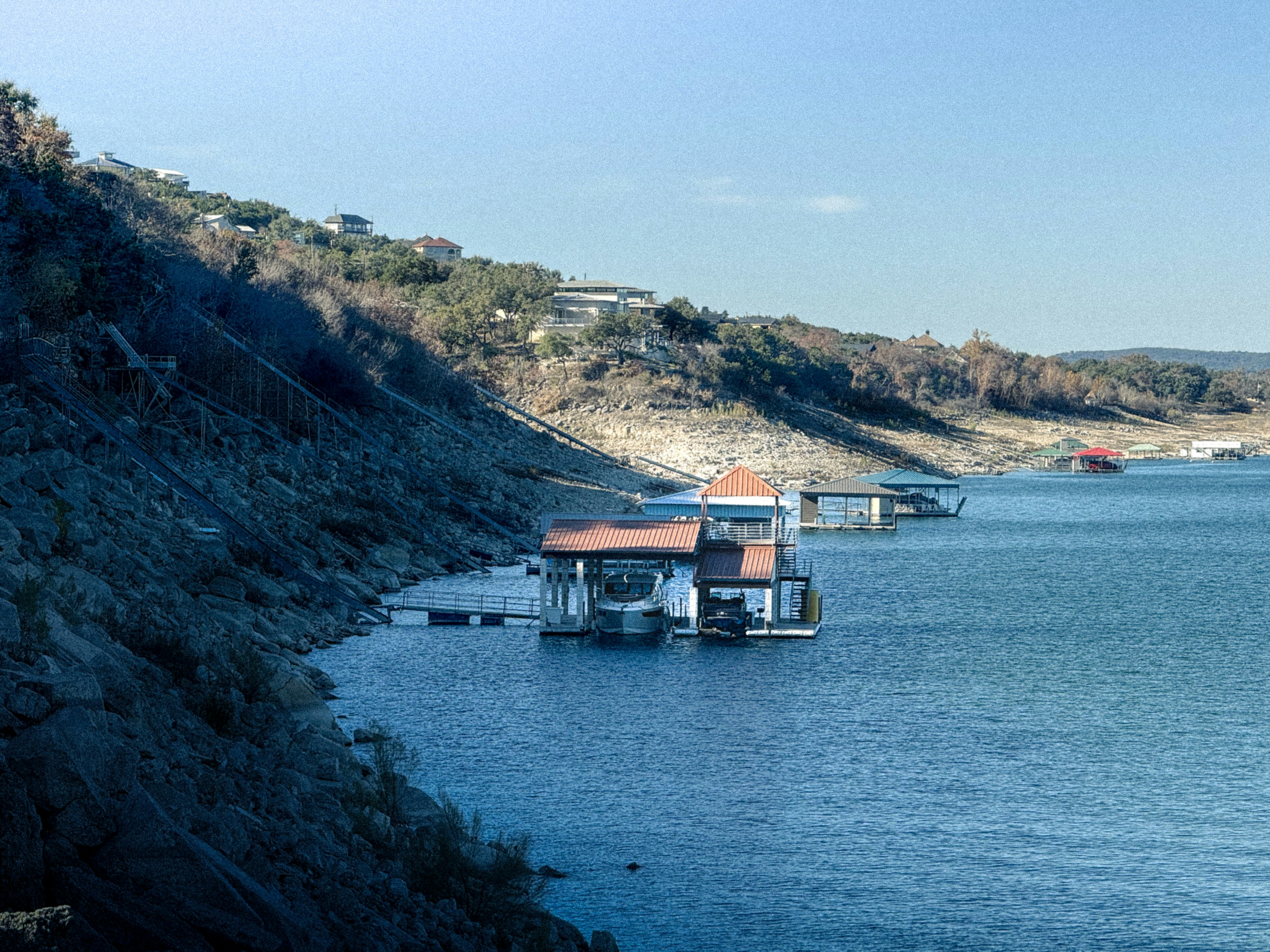 Rocky shoreline escapes a quiet cove with floating boathouses