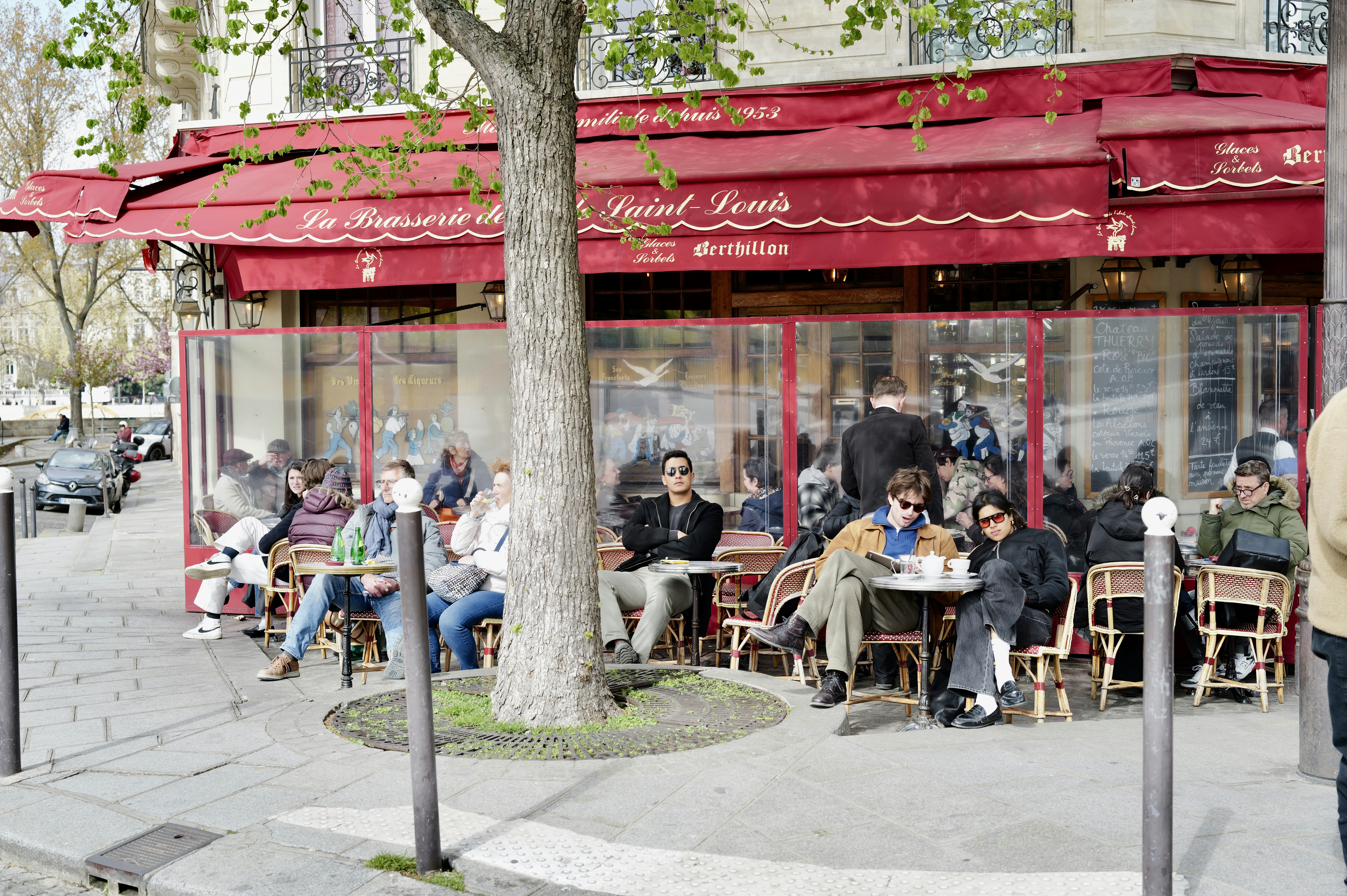 Cafe Courtyard Heads: Neatly Dressed Patrons under Red Awnings
