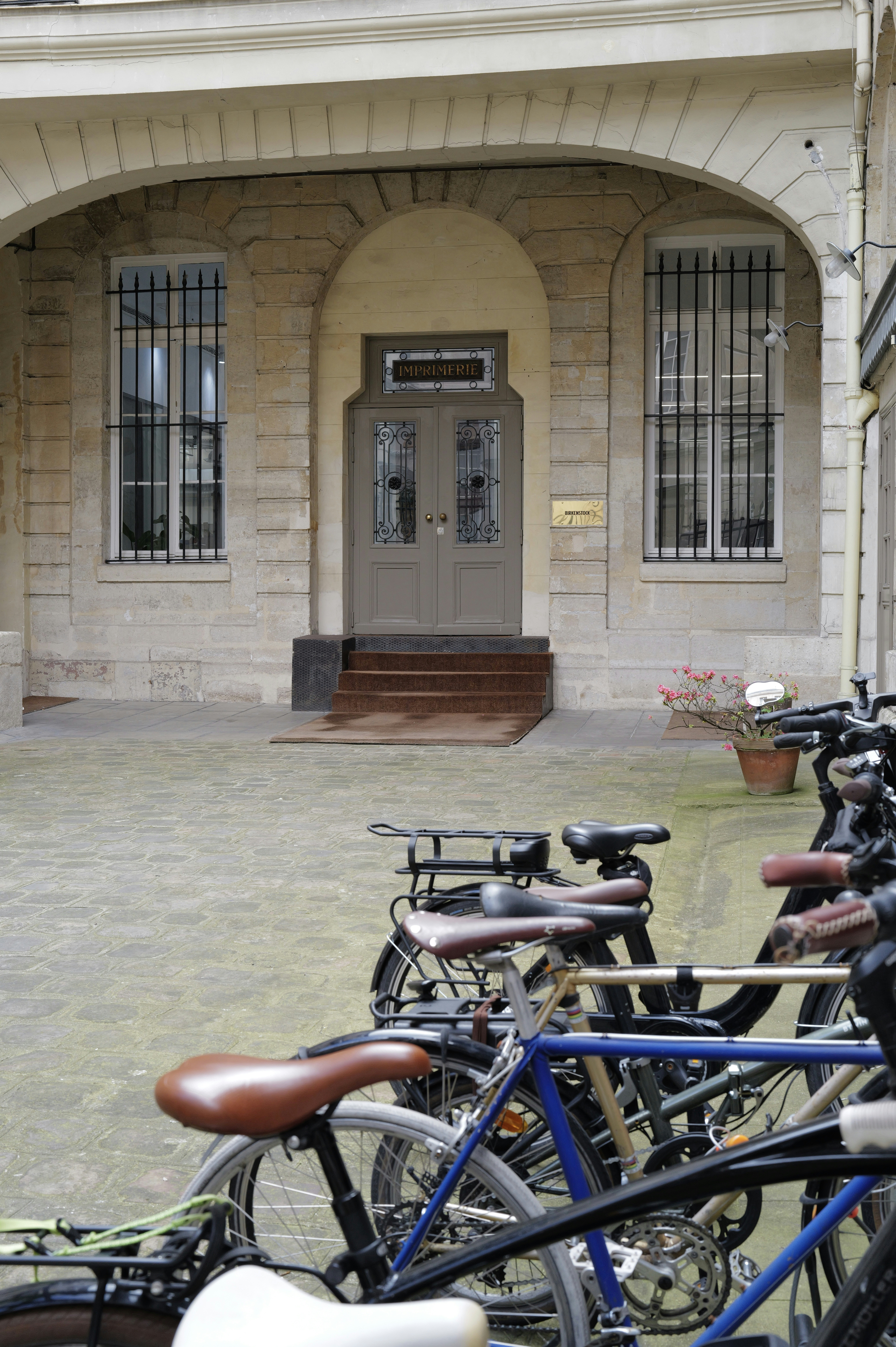 Grey-arched doorway of a historic storefront framed by parked bicycles