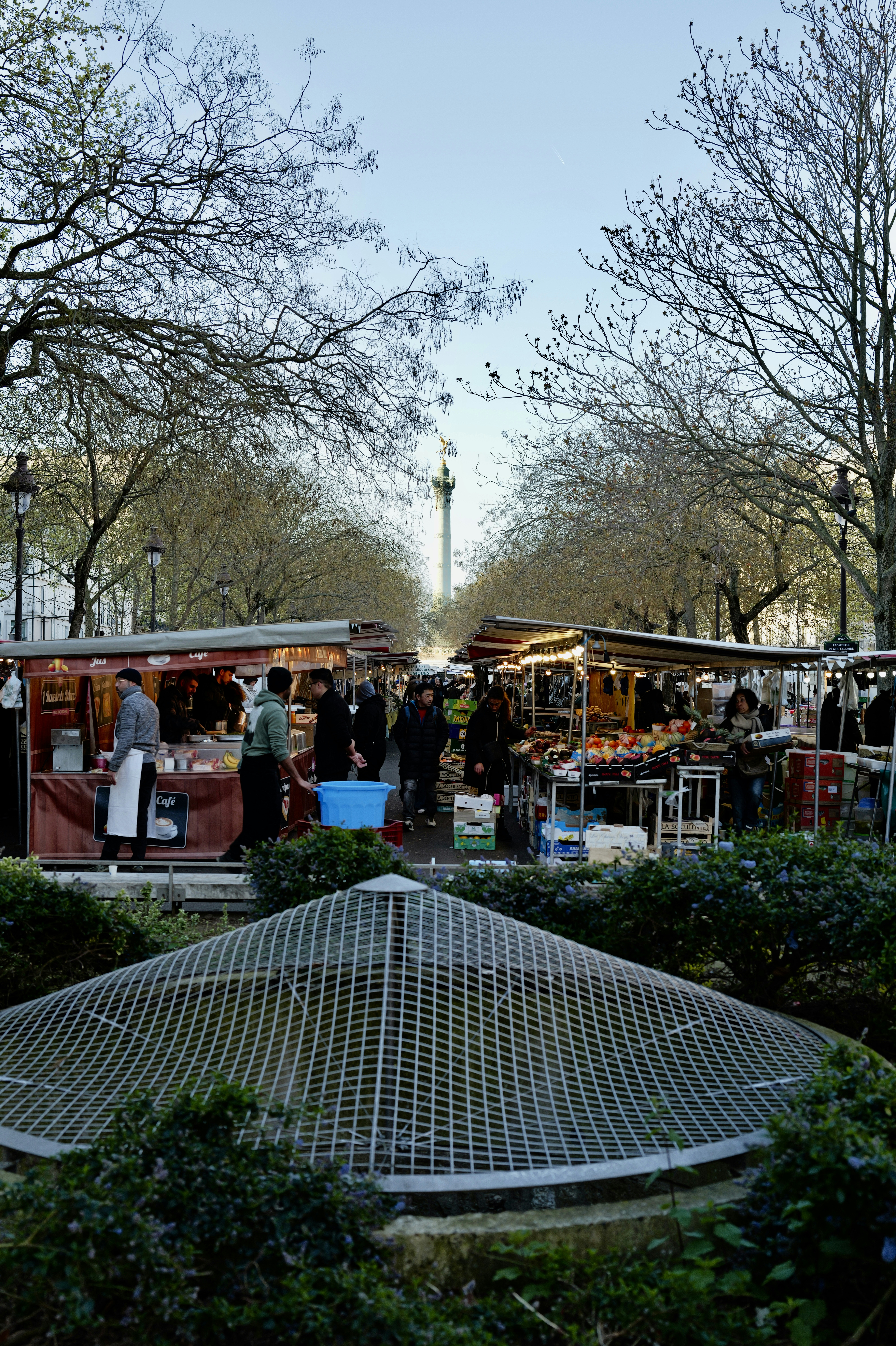 Market beneath the Parisian canopy: a sunny avenue of stalls and faces