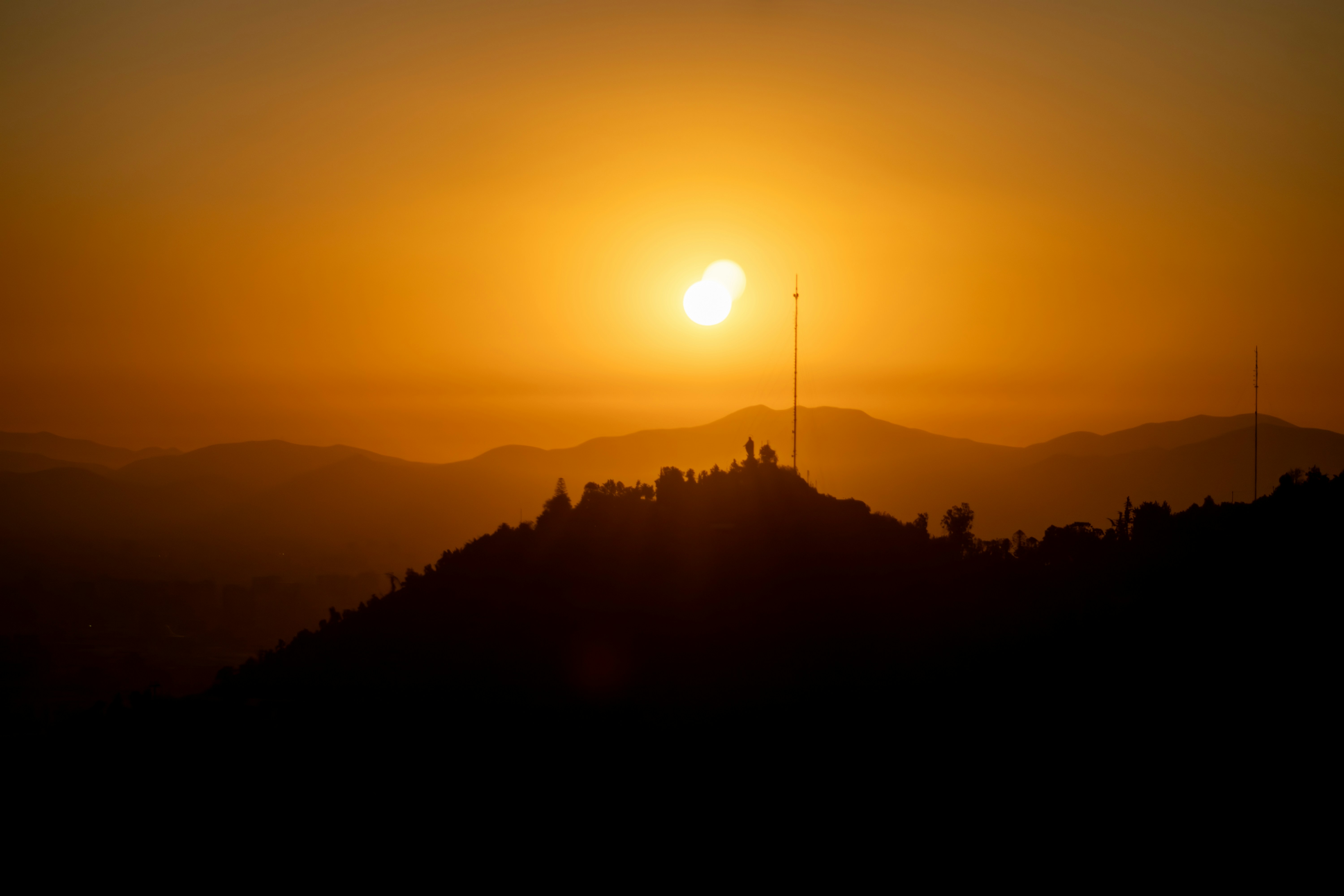 Sunset Sentinel: A Hilltop Silhouette Beneath a Golden Sky