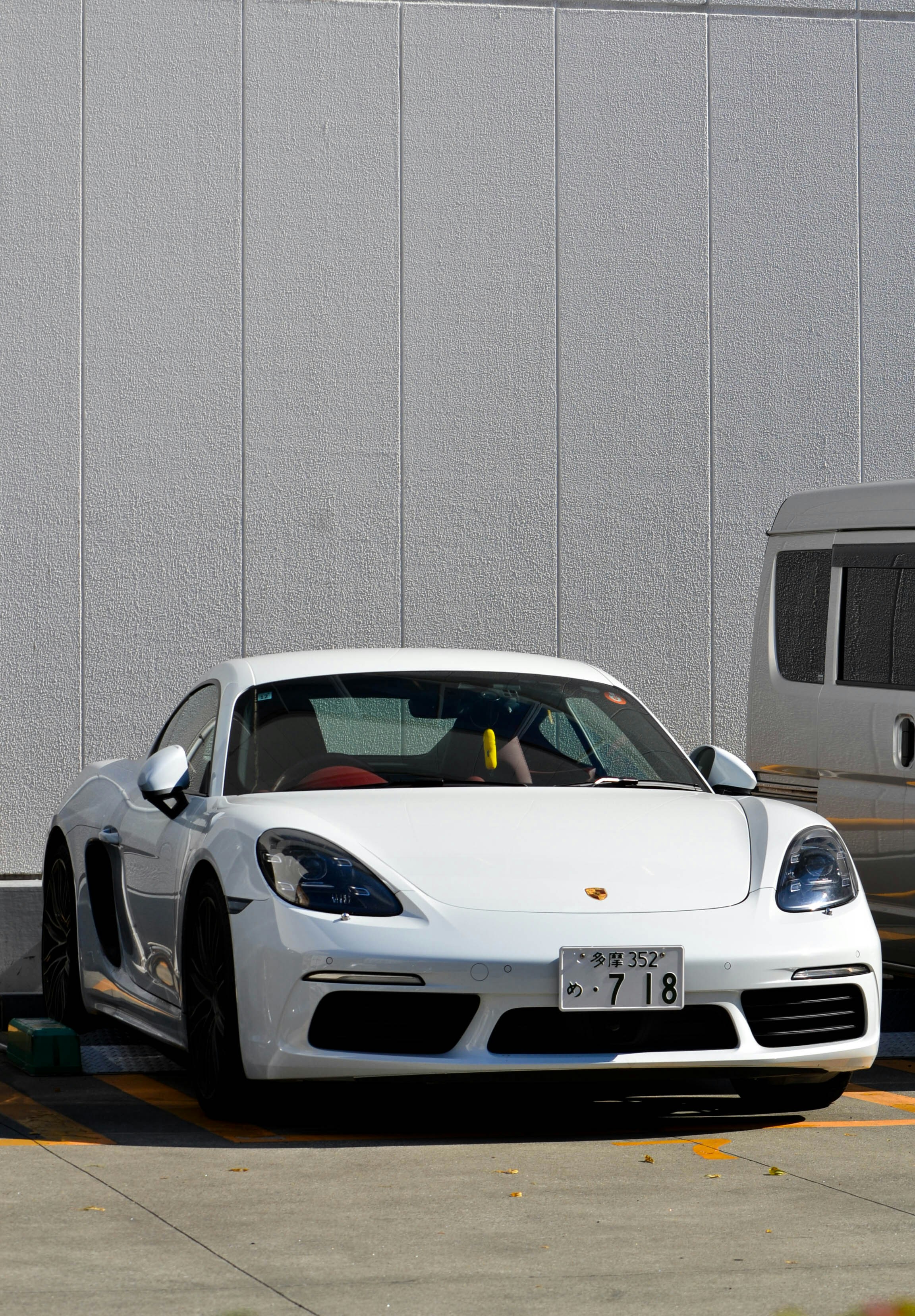 White Porsche Paired with a Silver Van in a Quiet Parking Lot