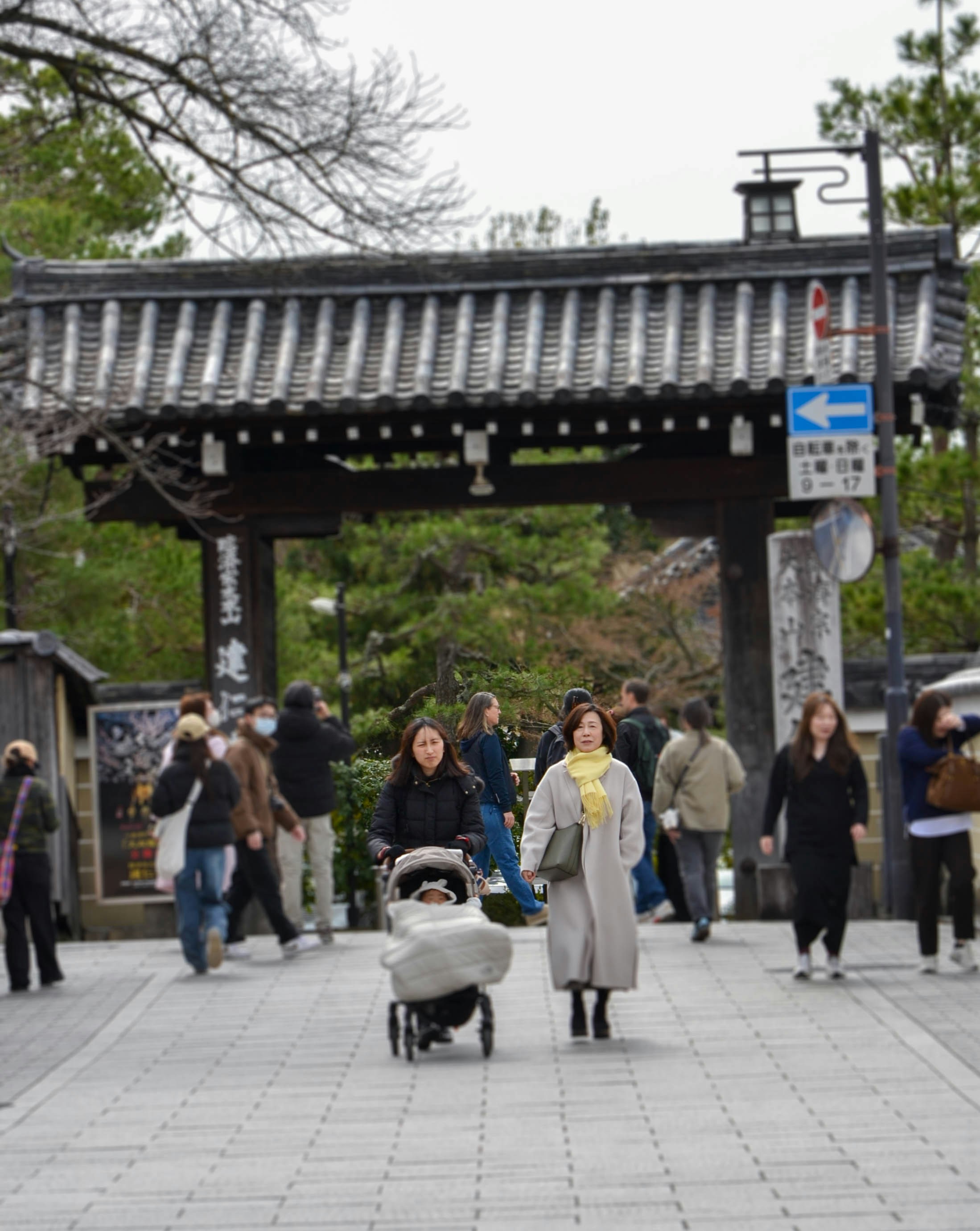 Street Scene Under a Traditional Gate: Passersby at the Temple Entrance