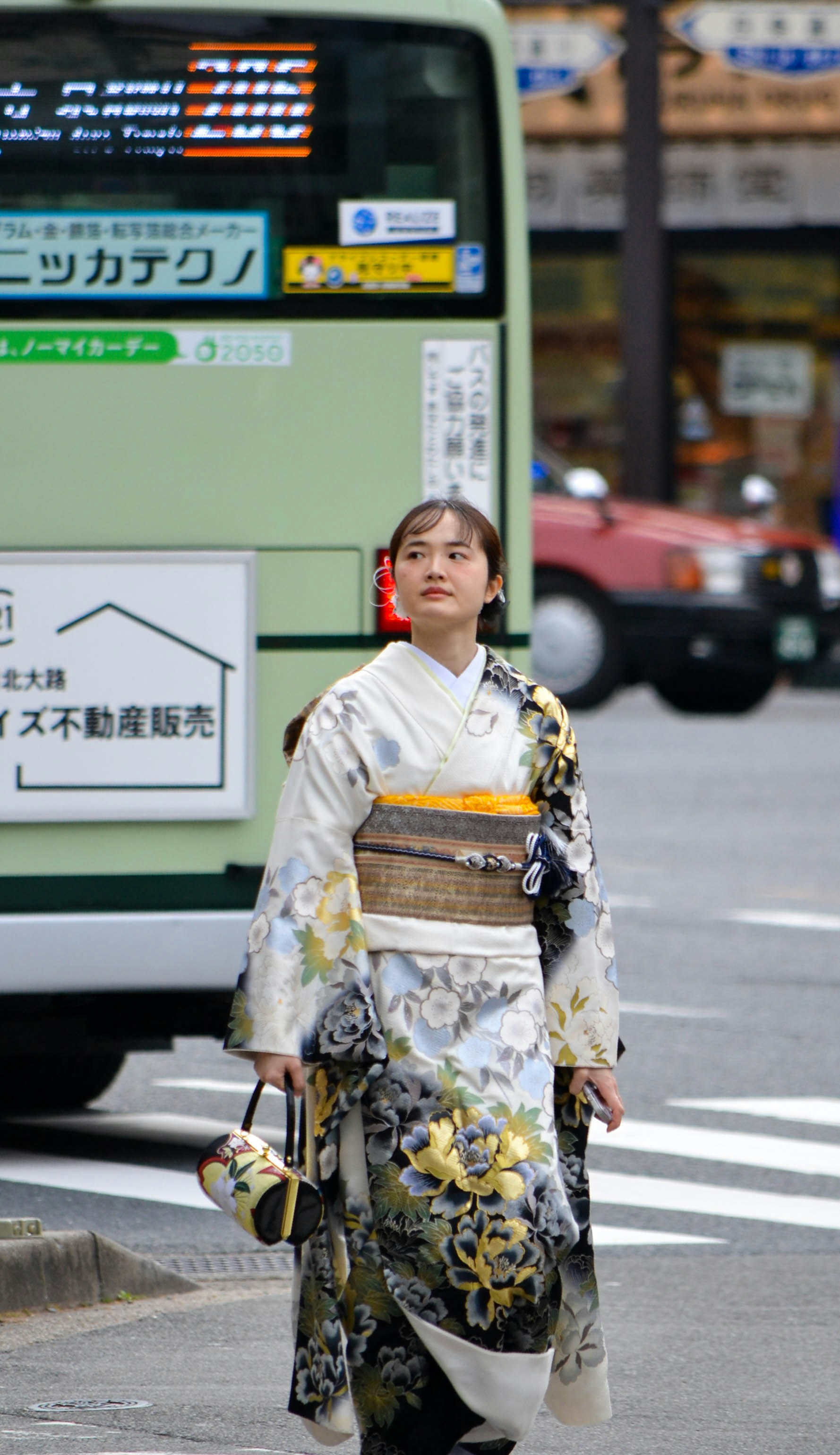 Kimono in Focus: A poised pedestrian against a city bus backdrop