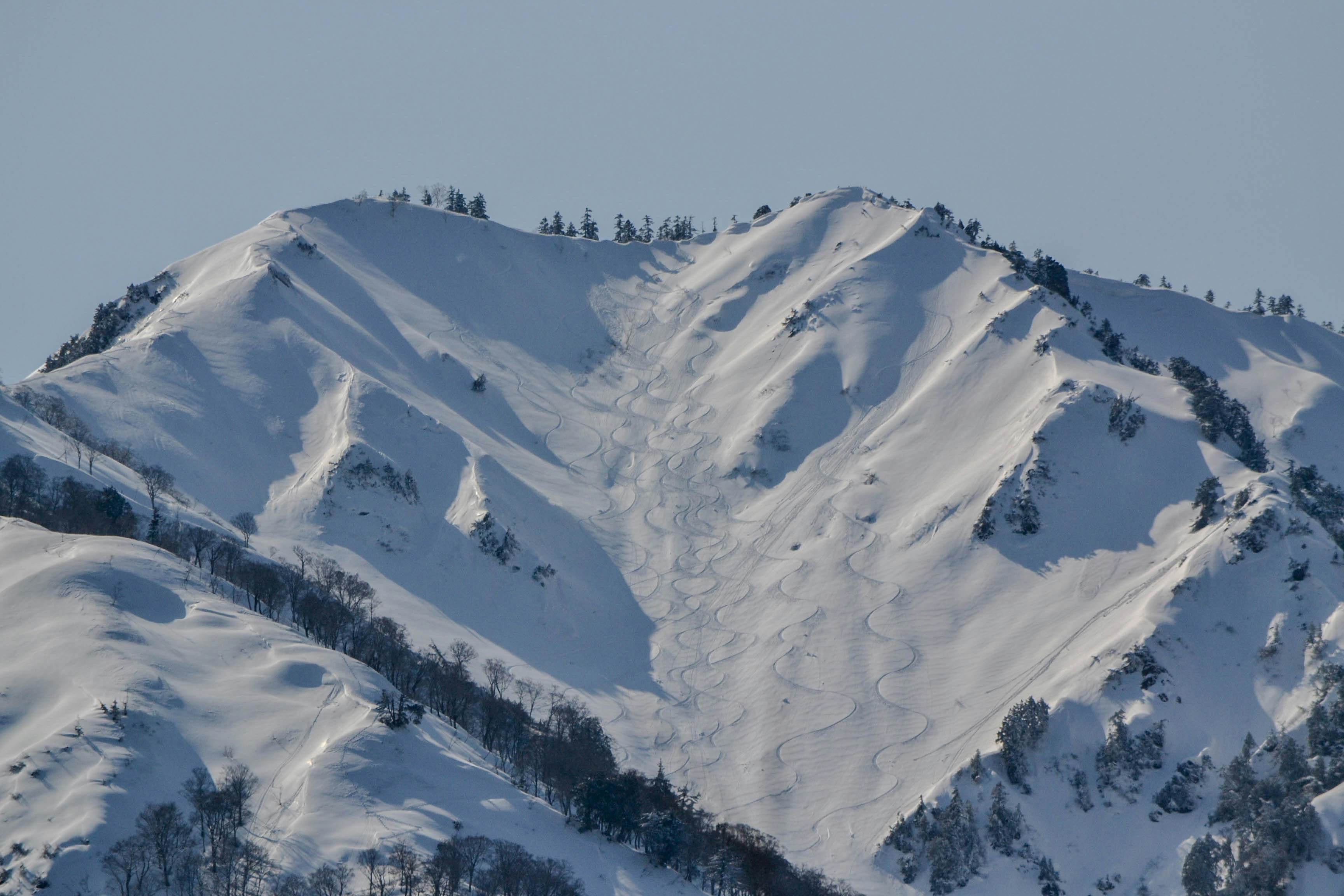 Ridge Line Whorls: Snow-Crunched Slopes Under Quiet Sky